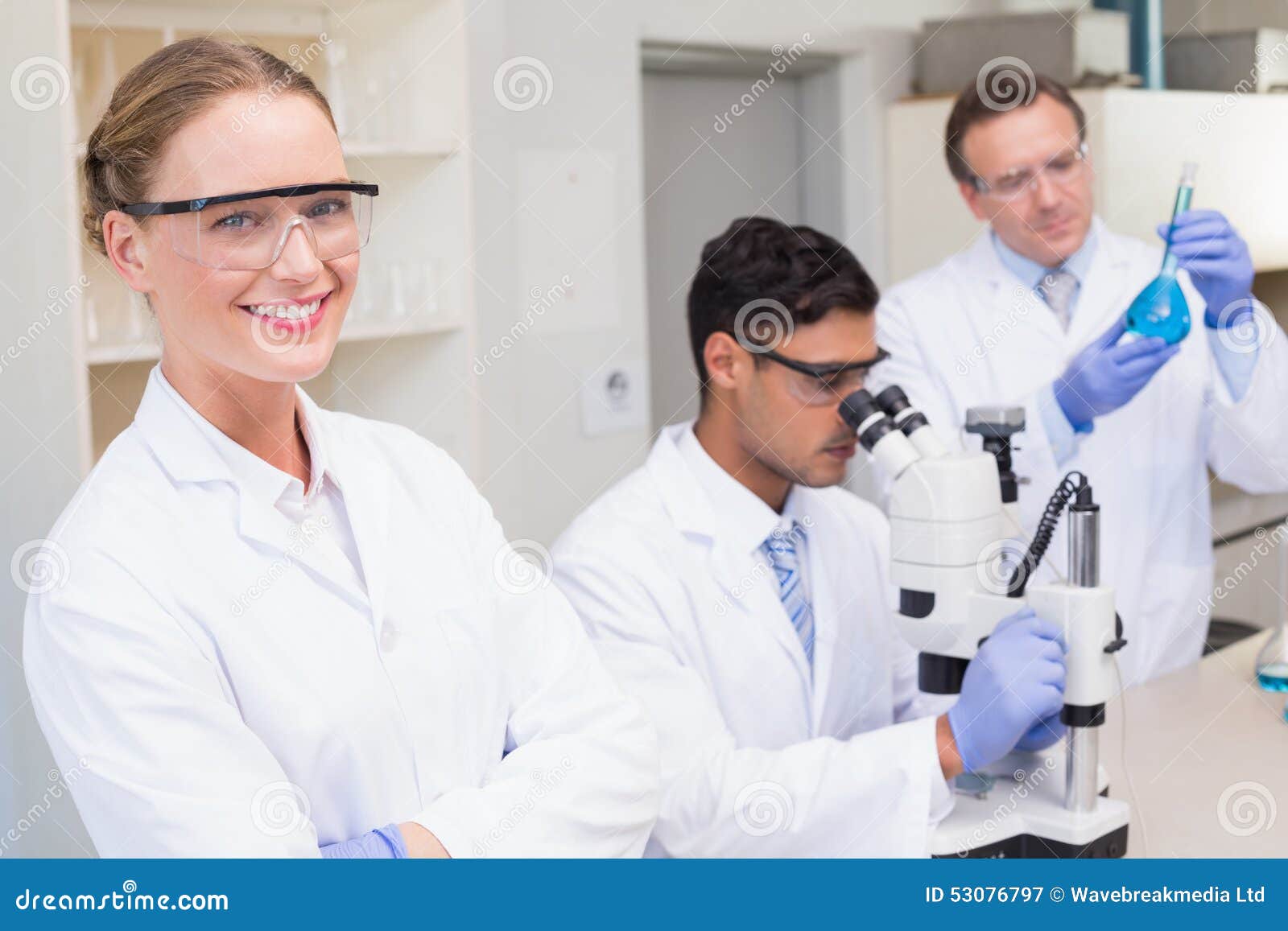 Smiling Scientist Looking at Camera while Colleagues Working with ...