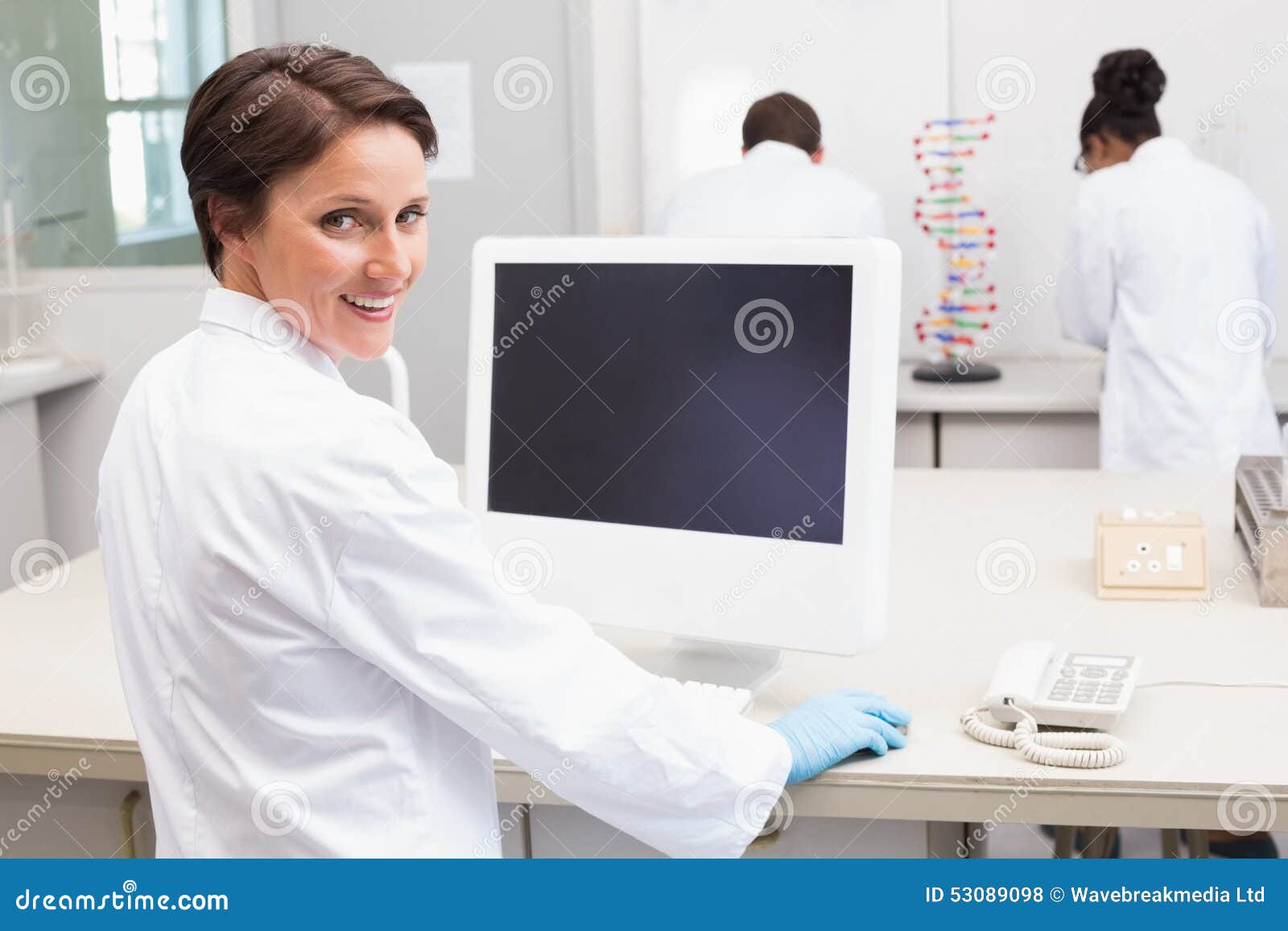 Smiling Scientist Using Computer while Colleagues Working Stock Photo ...