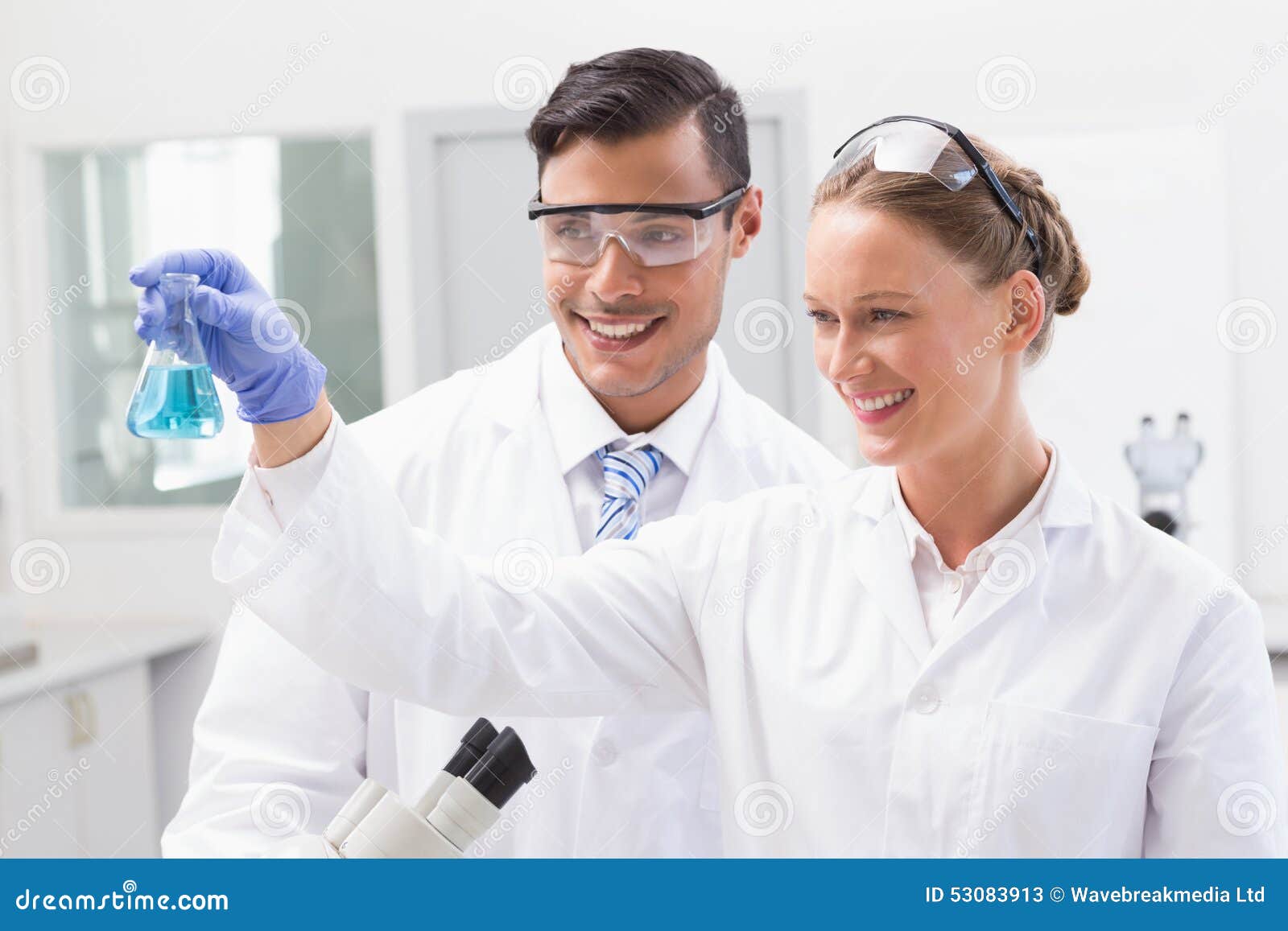 Smiling Scientists Looking at Beaker Stock Image - Image of people ...