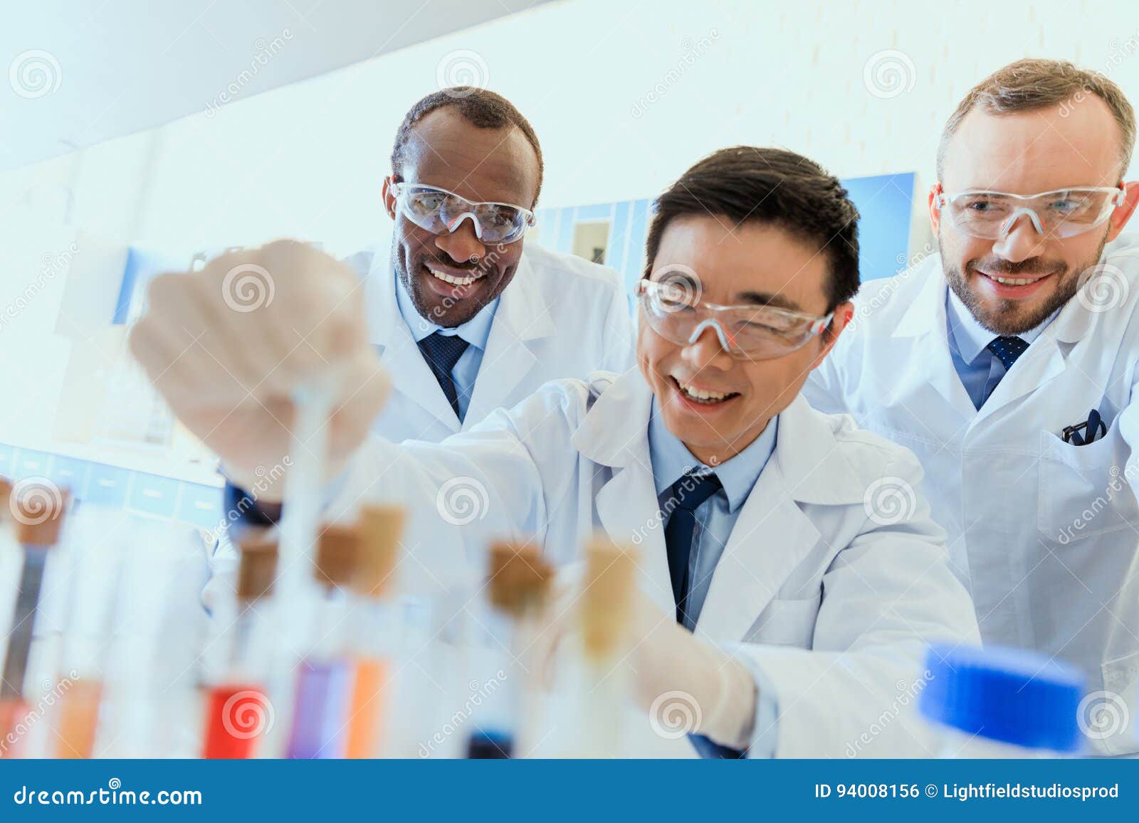 Smiling Scientists in Protective Eyeglasses Working Together in ...