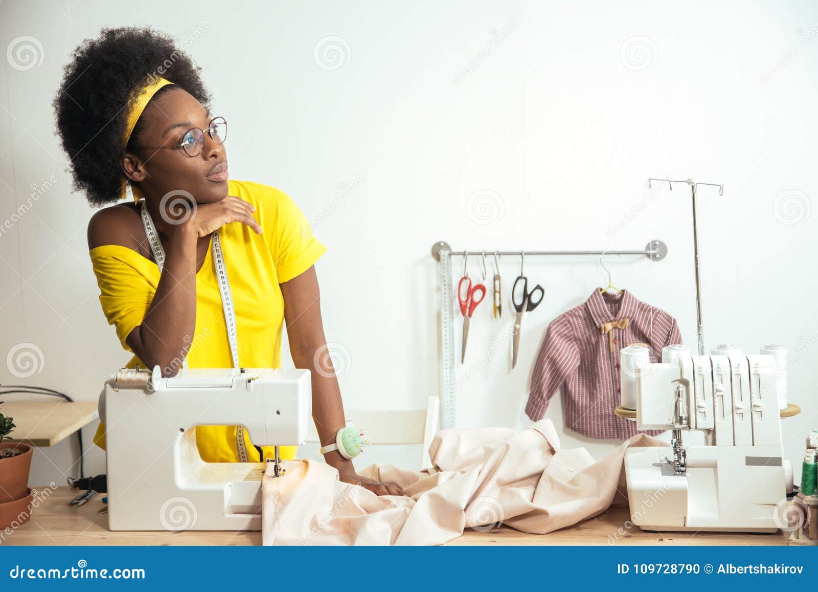 Smiling Seamstress Looking at Camera with Sewing Machine Stock Photo ...
