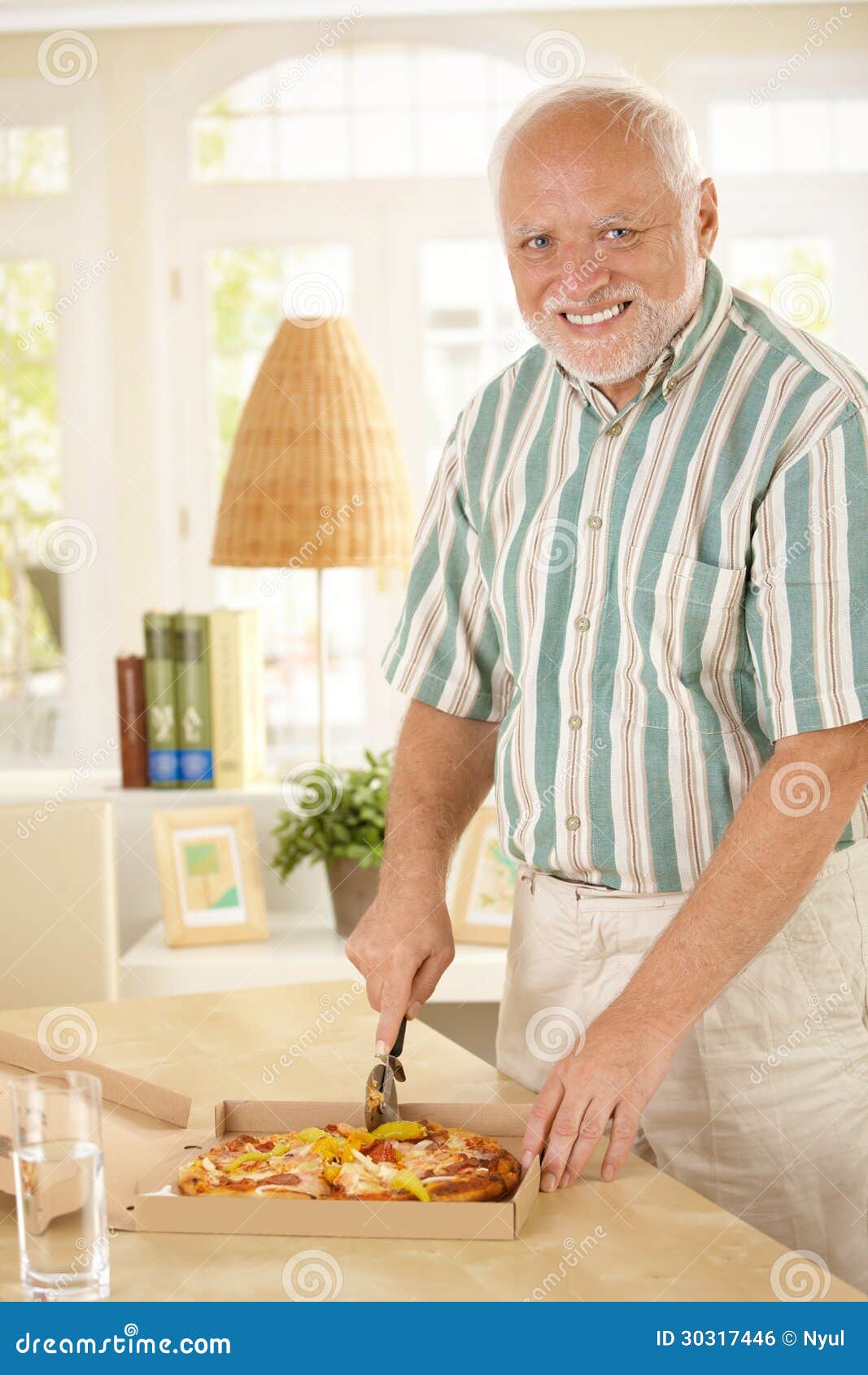 Smiling Senior Man Cutting Up Pizza Stock Photo - Image of contact ...
