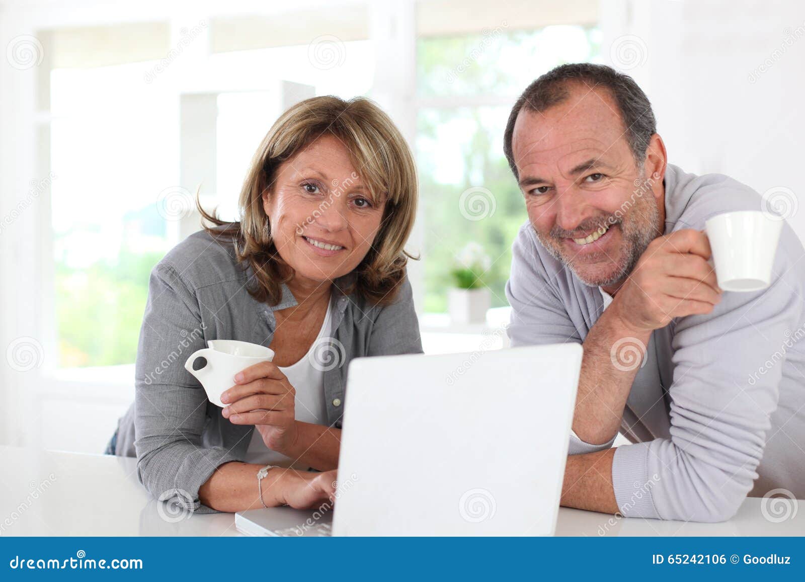 Smiling Seniors Drinking Coffee Using Laptop Stock Photo - Image of ...
