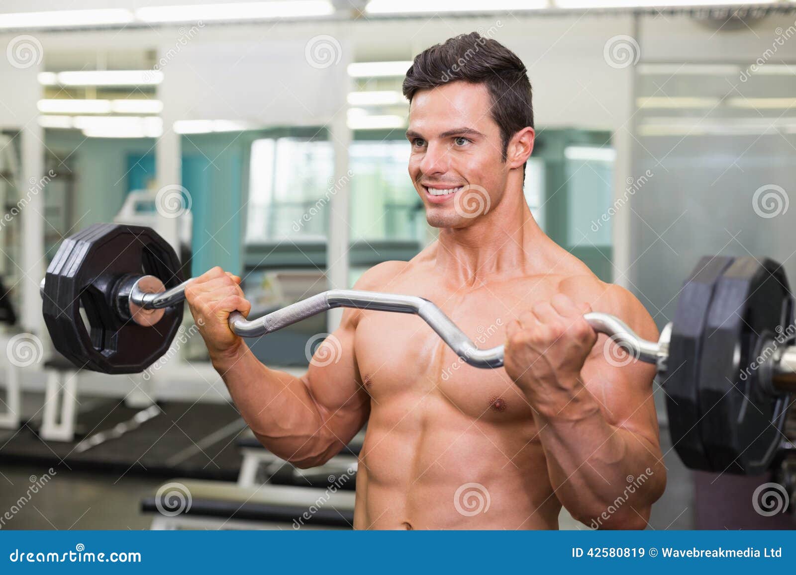 Smiling Shirtless Muscular Man Lifting Barbell In Gym Stock Image