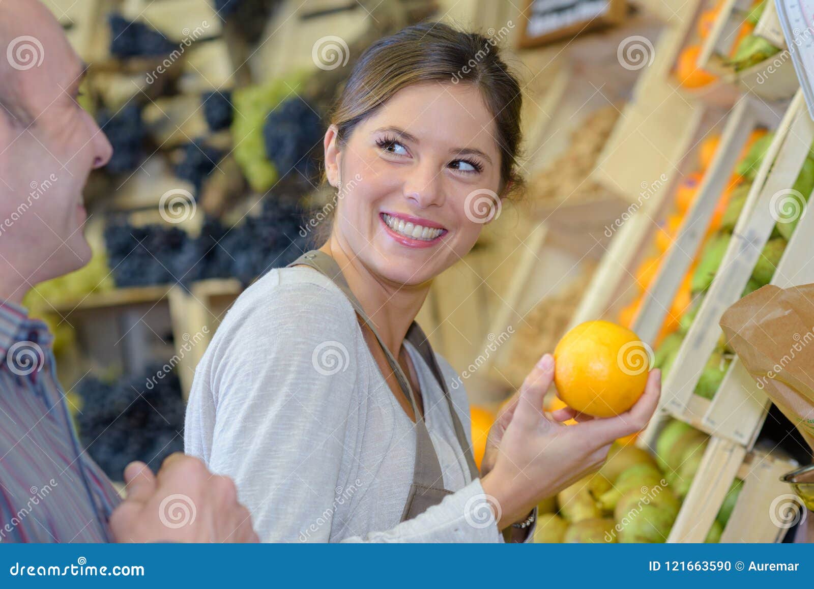 Smiling Shop Assistant Holding Orange Stock Photo - Image of relaxed ...
