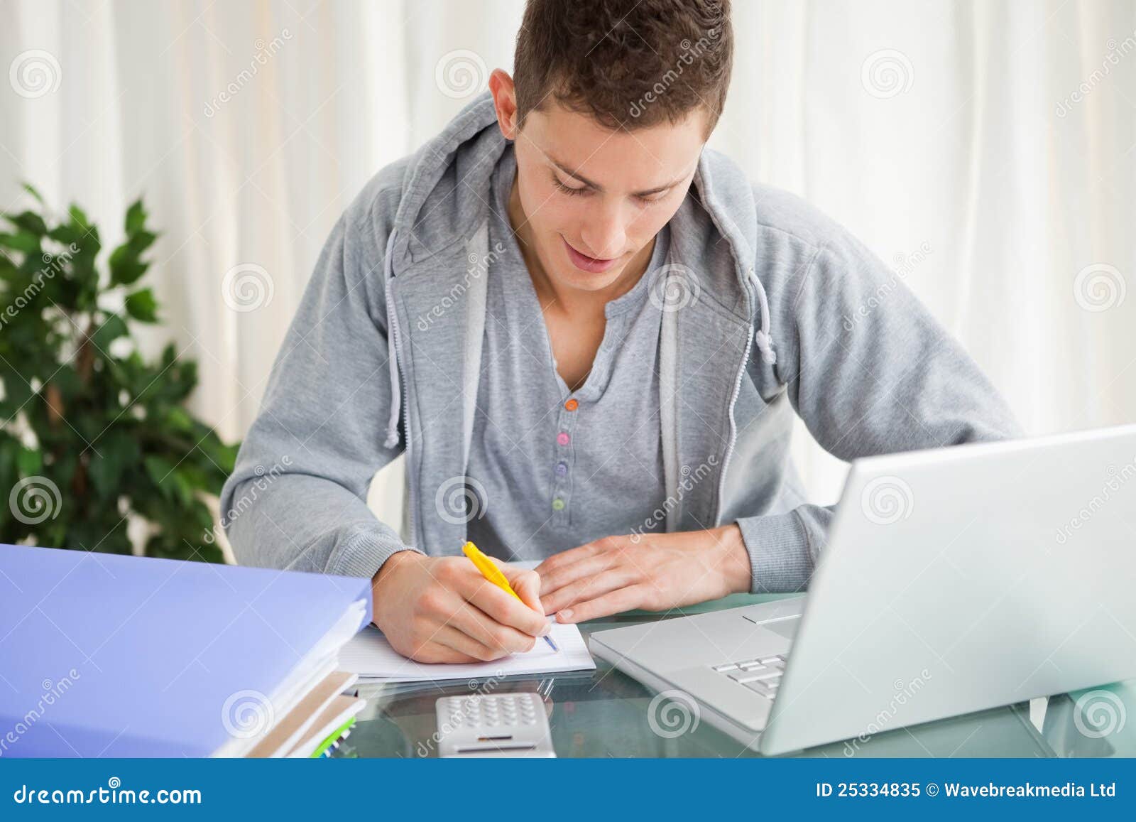 Smiling Student Doing His Homework with a Laptop Stock Image - Image of ...