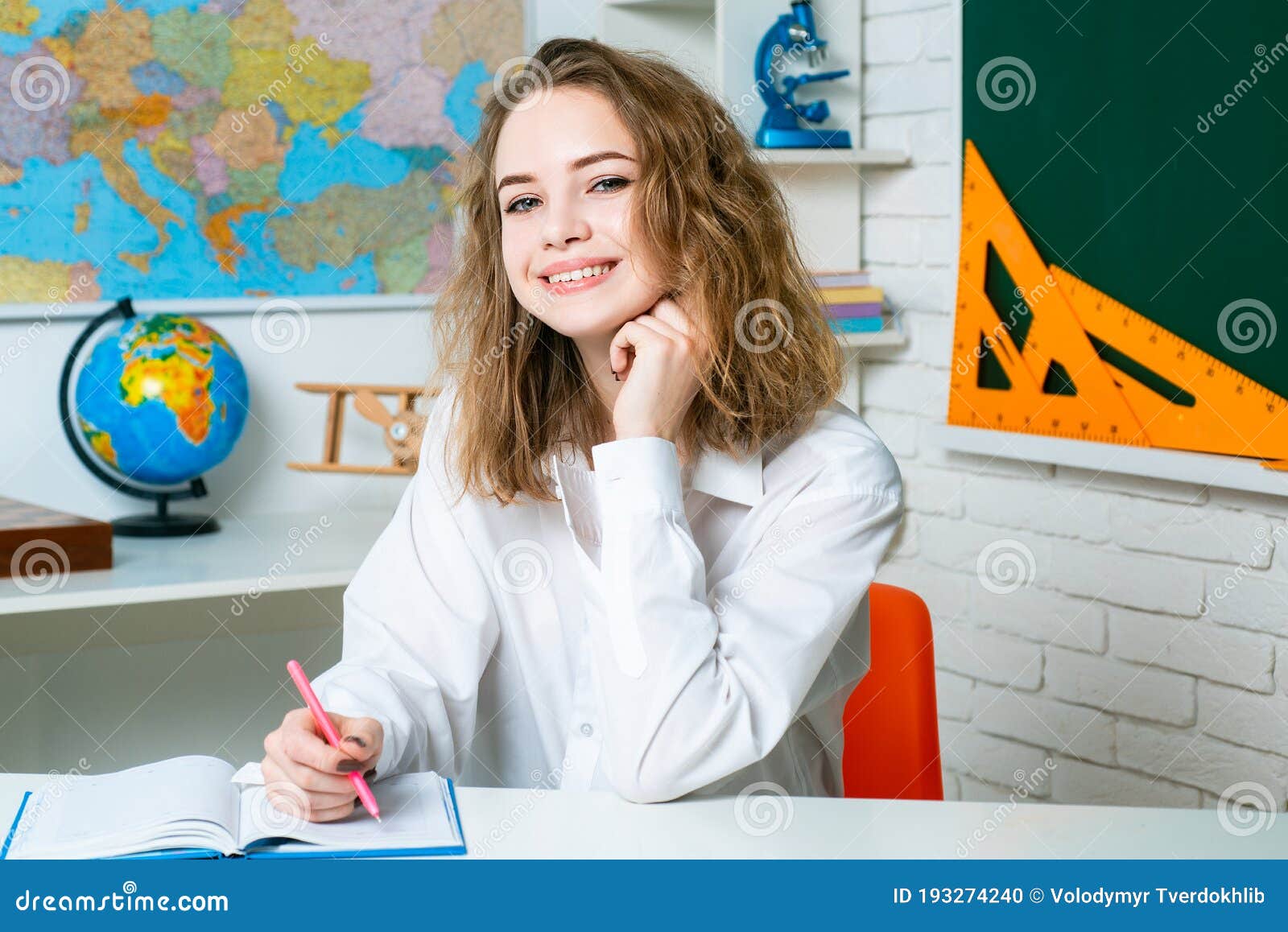 Smiling Student Girl Posing in the Class, Holding Books and Looking at ...