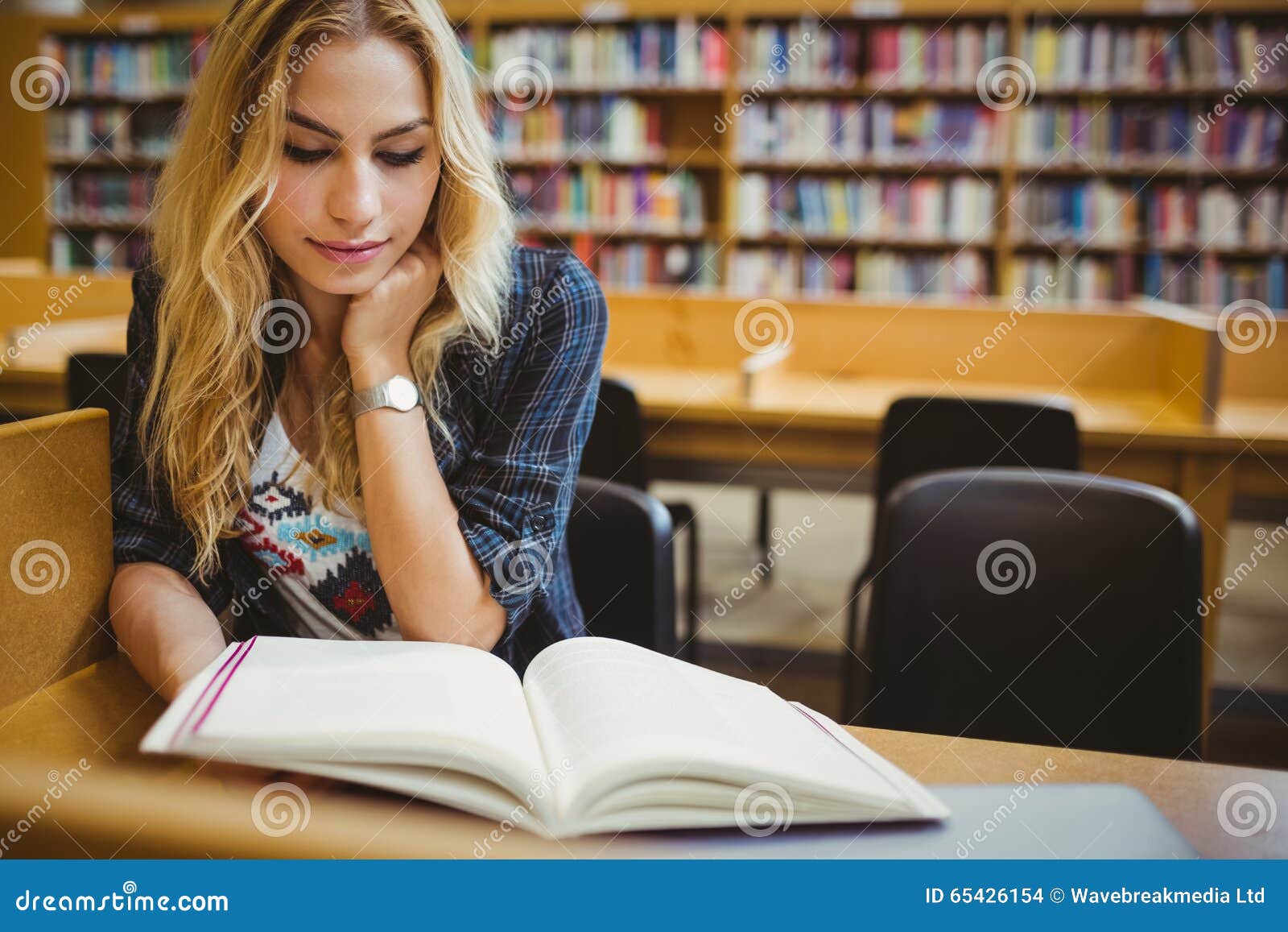 Smiling Student Reading a Book at Table Stock Photo - Image of ...