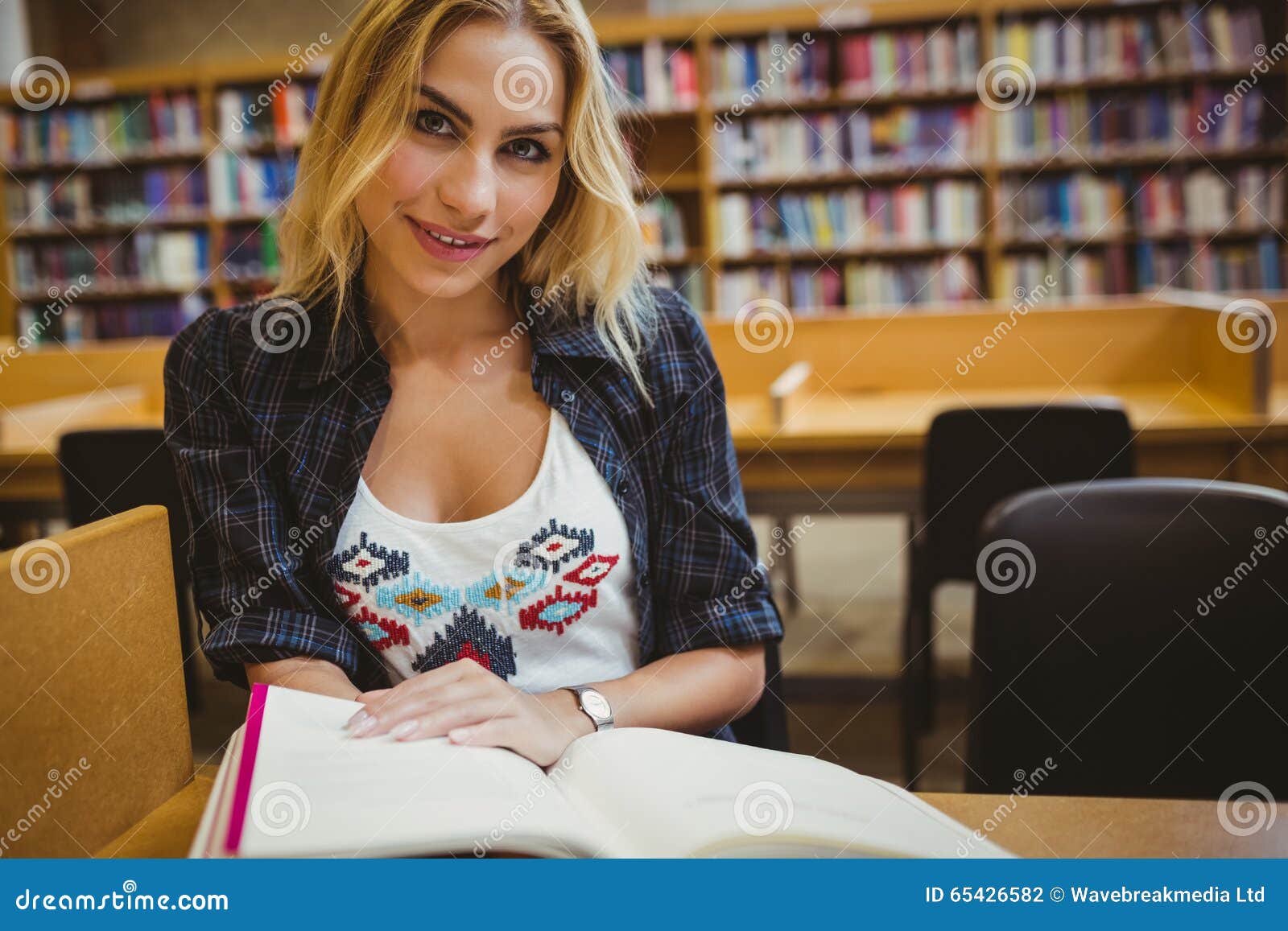 Smiling Student Reading a Book at Table Stock Photo - Image of desk ...