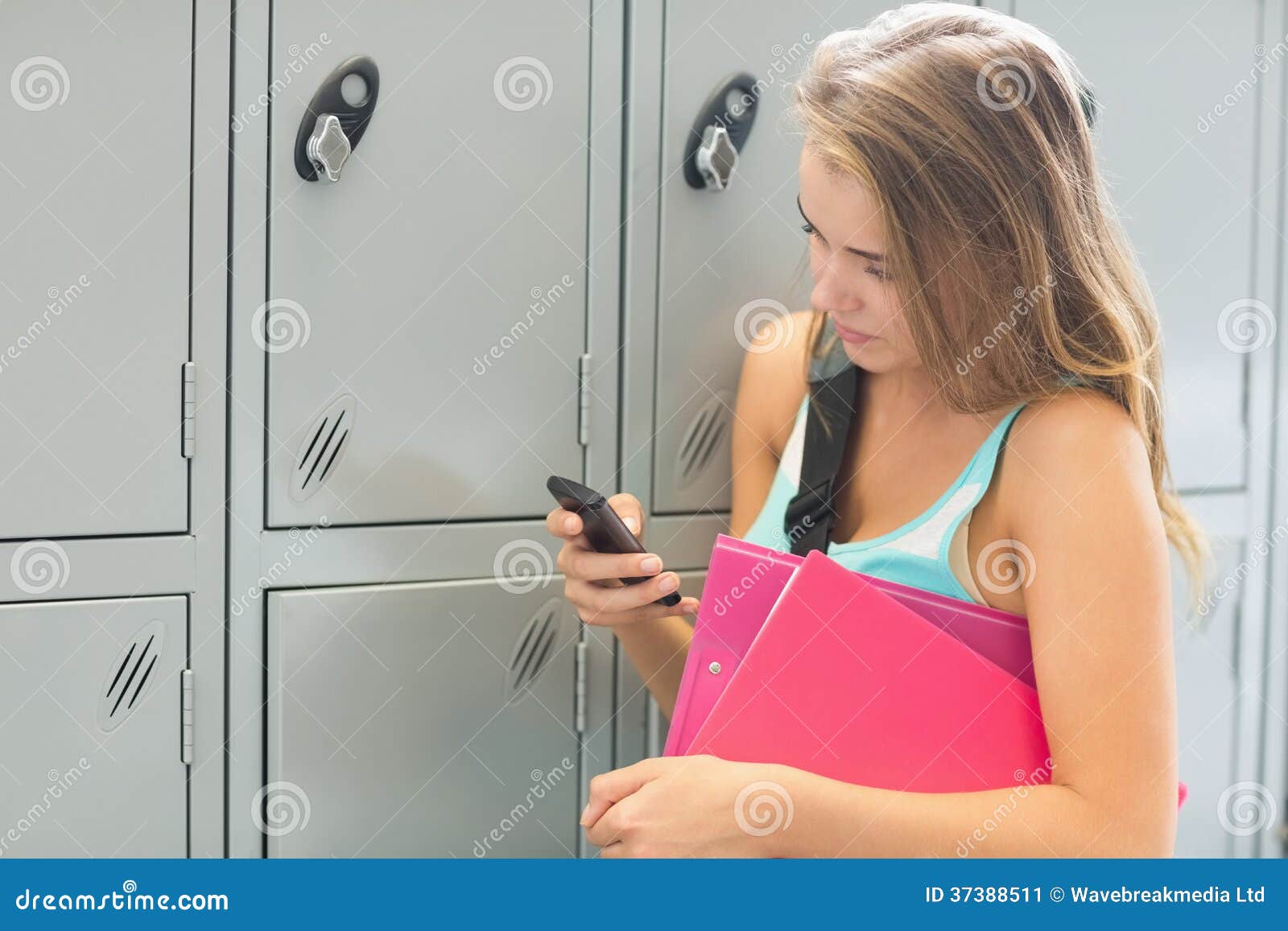 Smiling Student Sending a Text beside Lockers Stock Image - Image of ...