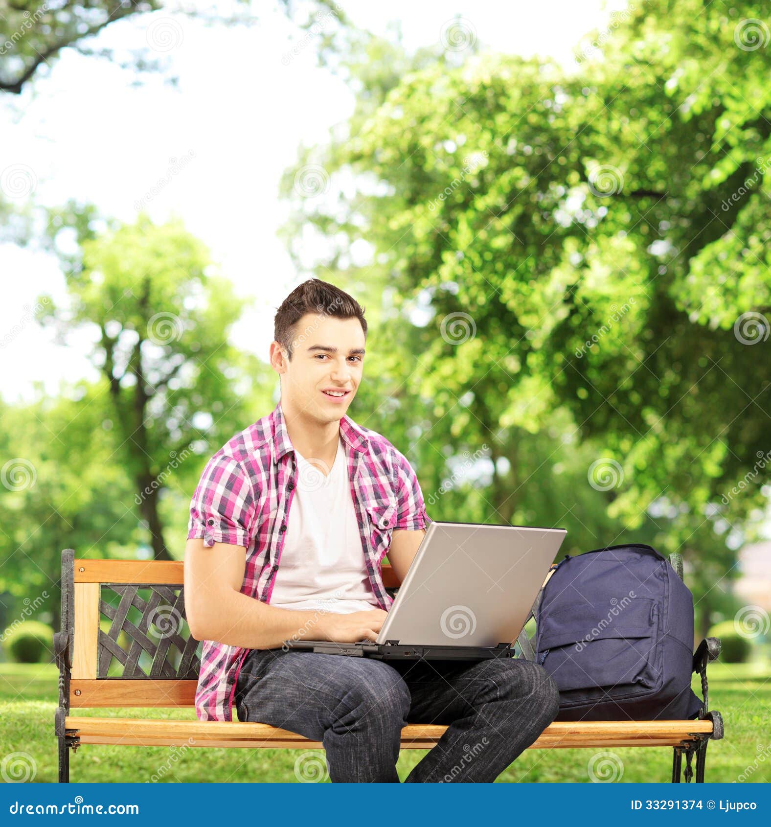 Smiling Student Sitting on a Bench and Working on a Computer Stock ...