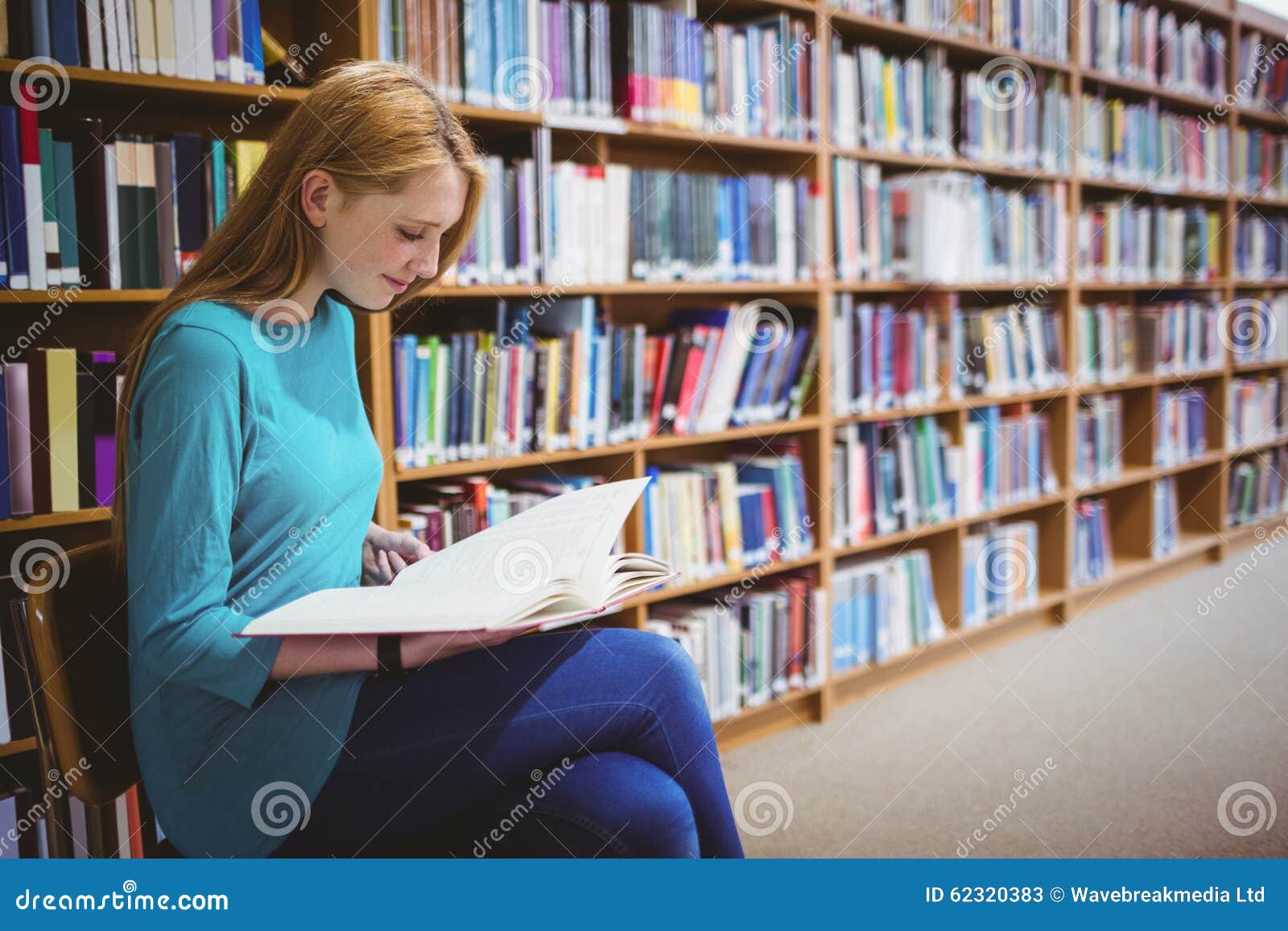 Smiling Student Sitting on Chair Reading Book in Library Stock Image ...