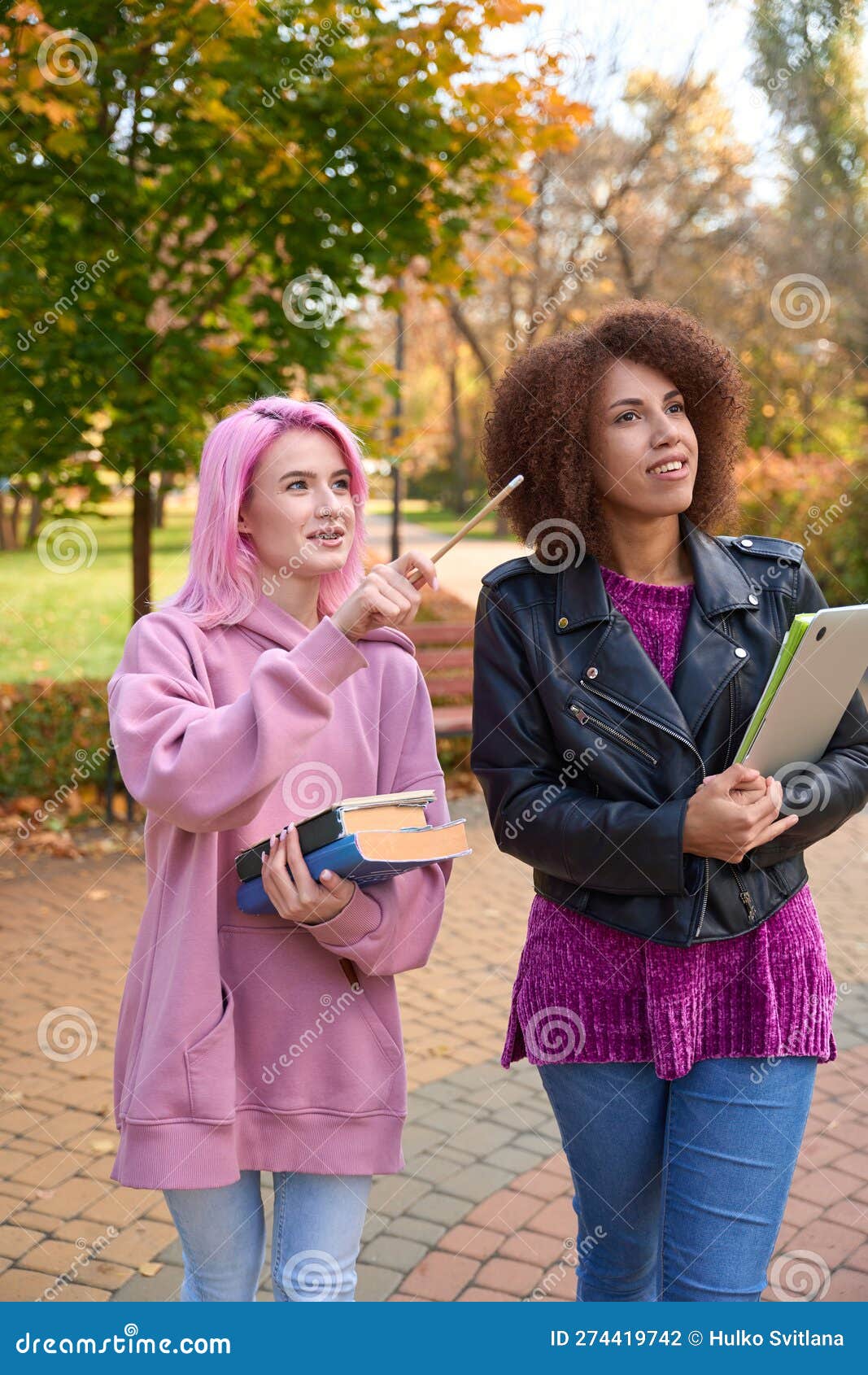 Smiling Students in Park Staring into Distance Stock Photo - Image of ...