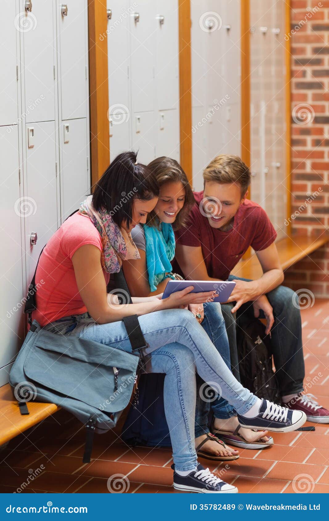 Smiling Students Sitting on Bench Using Tablet Stock Image - Image of ...