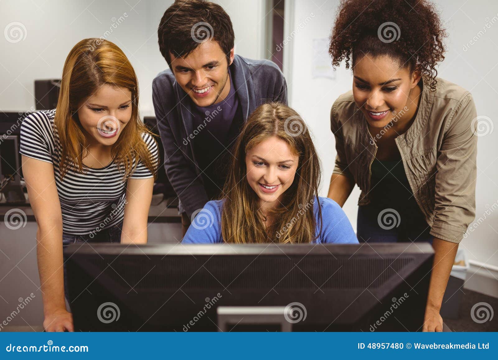 Smiling Students Sitting at Desk Using Computer Together Stock Photo ...