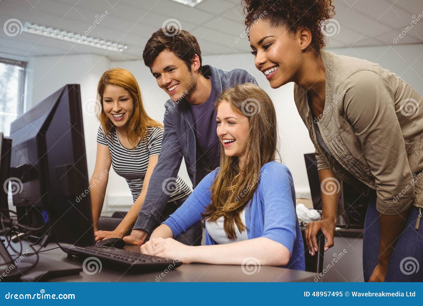 Smiling Students Sitting at Desk Using Computer Together Stock Image ...