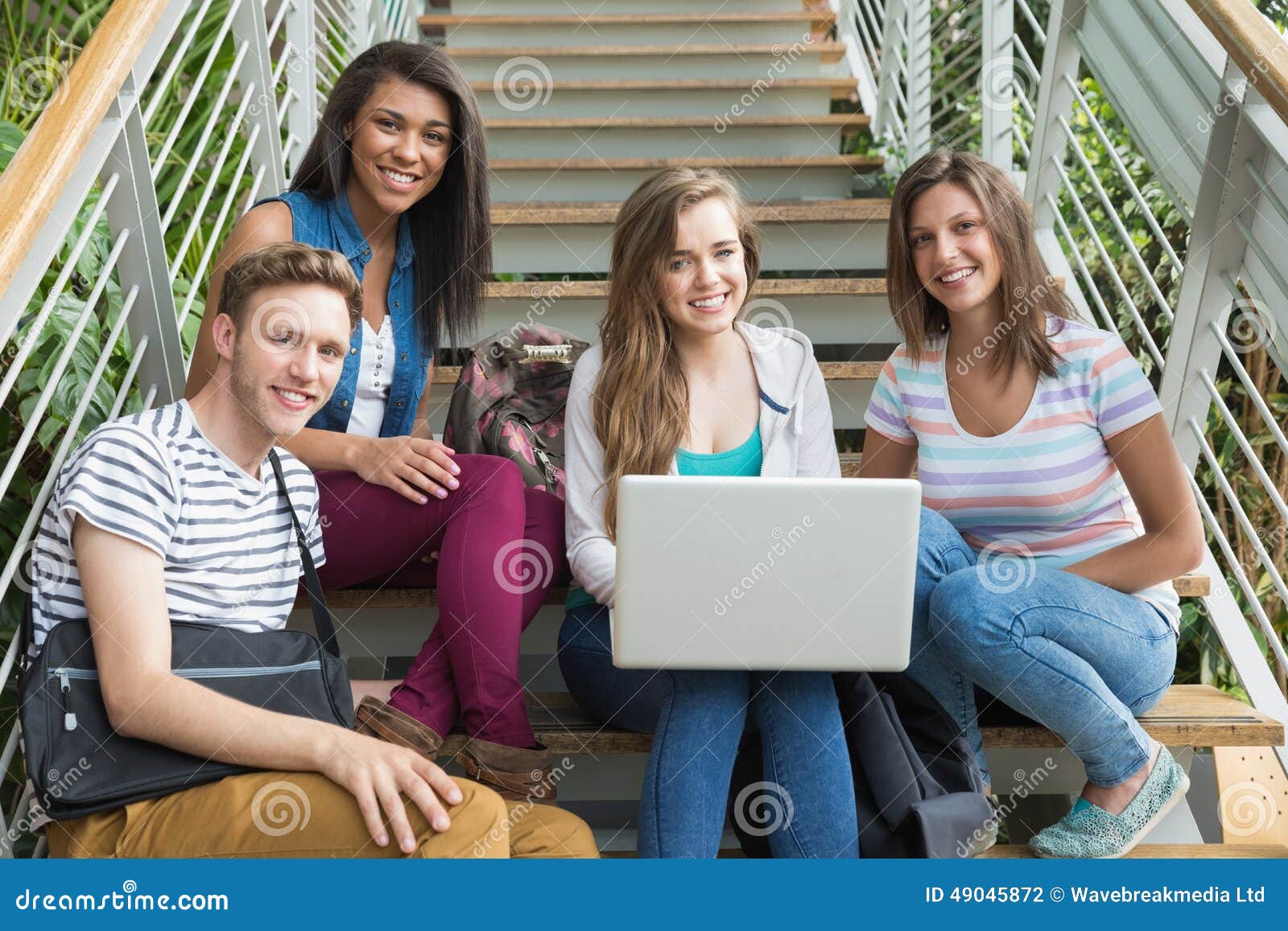 Smiling Students Sitting on Steps with Laptop Stock Photo - Image of ...