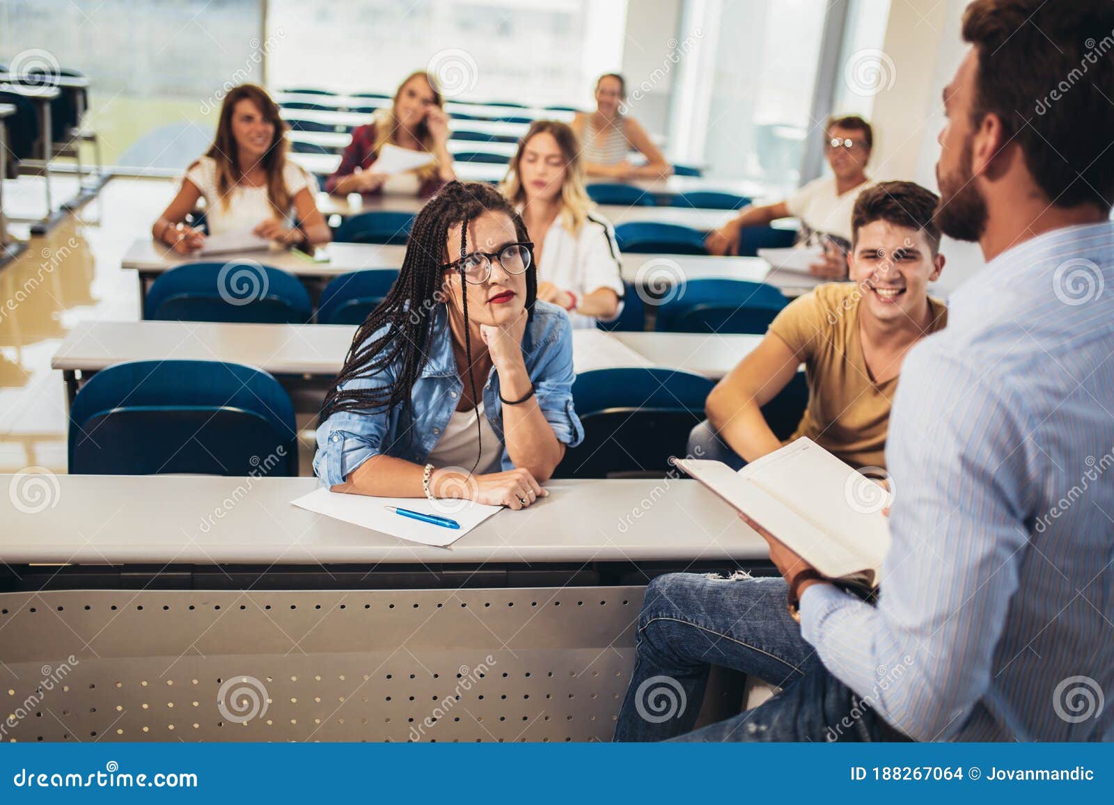 Smiling Students and Teacher with Notebook in Classroom Stock Photo ...