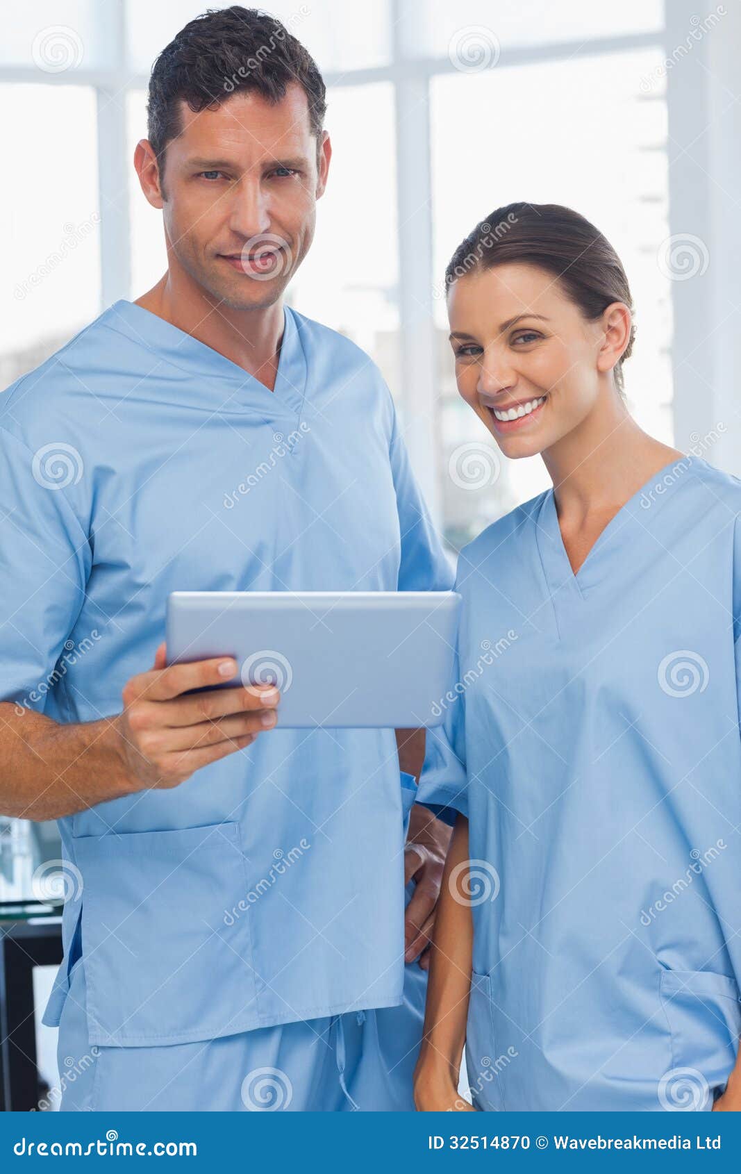 Smiling Surgeons Working Together on Tablet Stock Photo - Image of ...