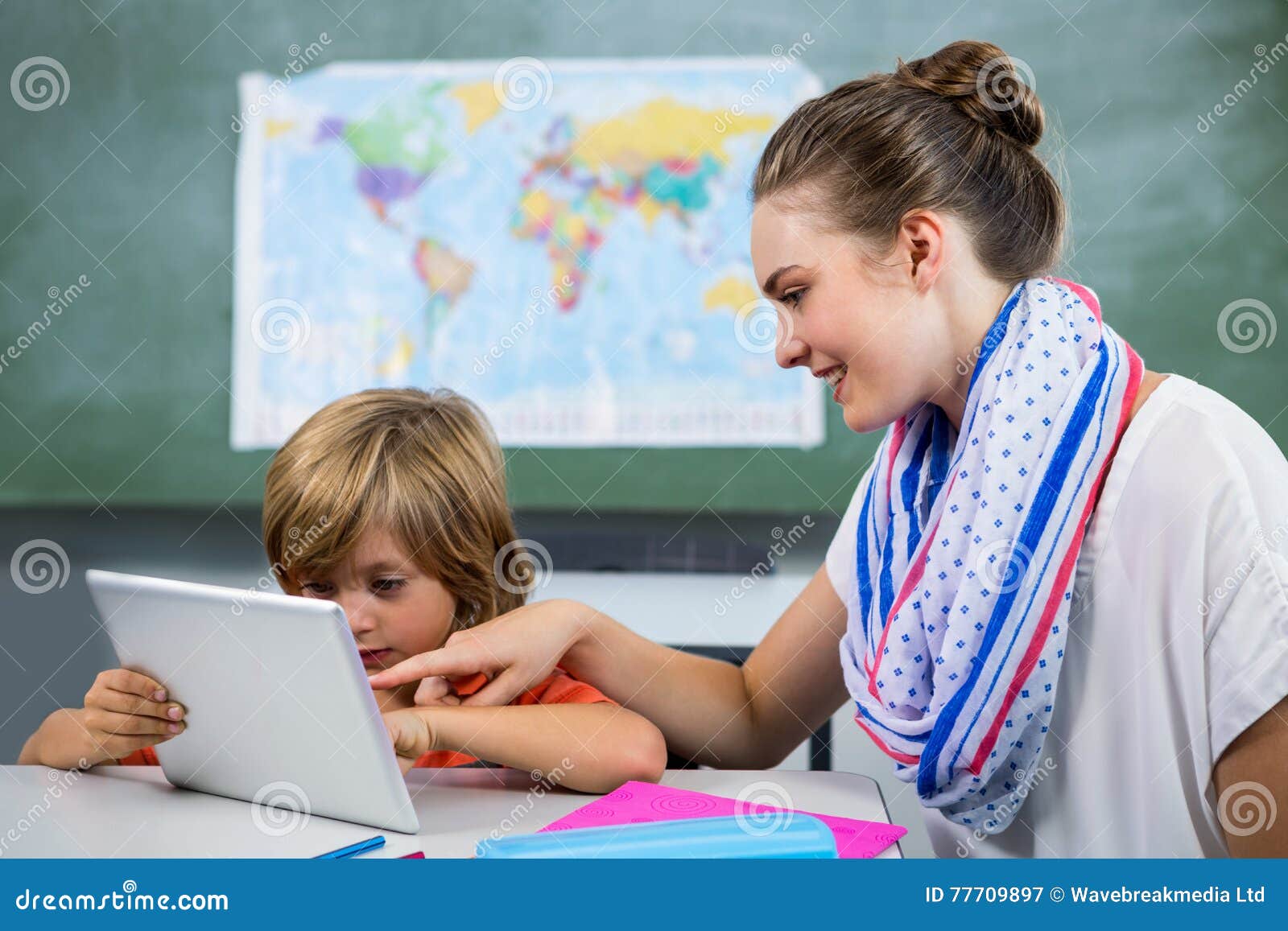 Smiling Teacher Assisting Boy Using Digital Tablet Stock Image - Image ...