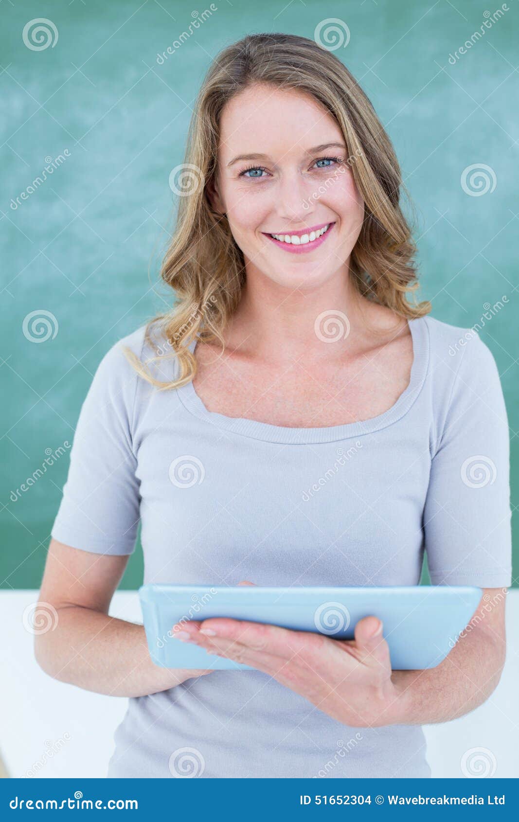 Smiling Teacher Holding Tablet Pc in Front of Blackboard Stock Photo ...