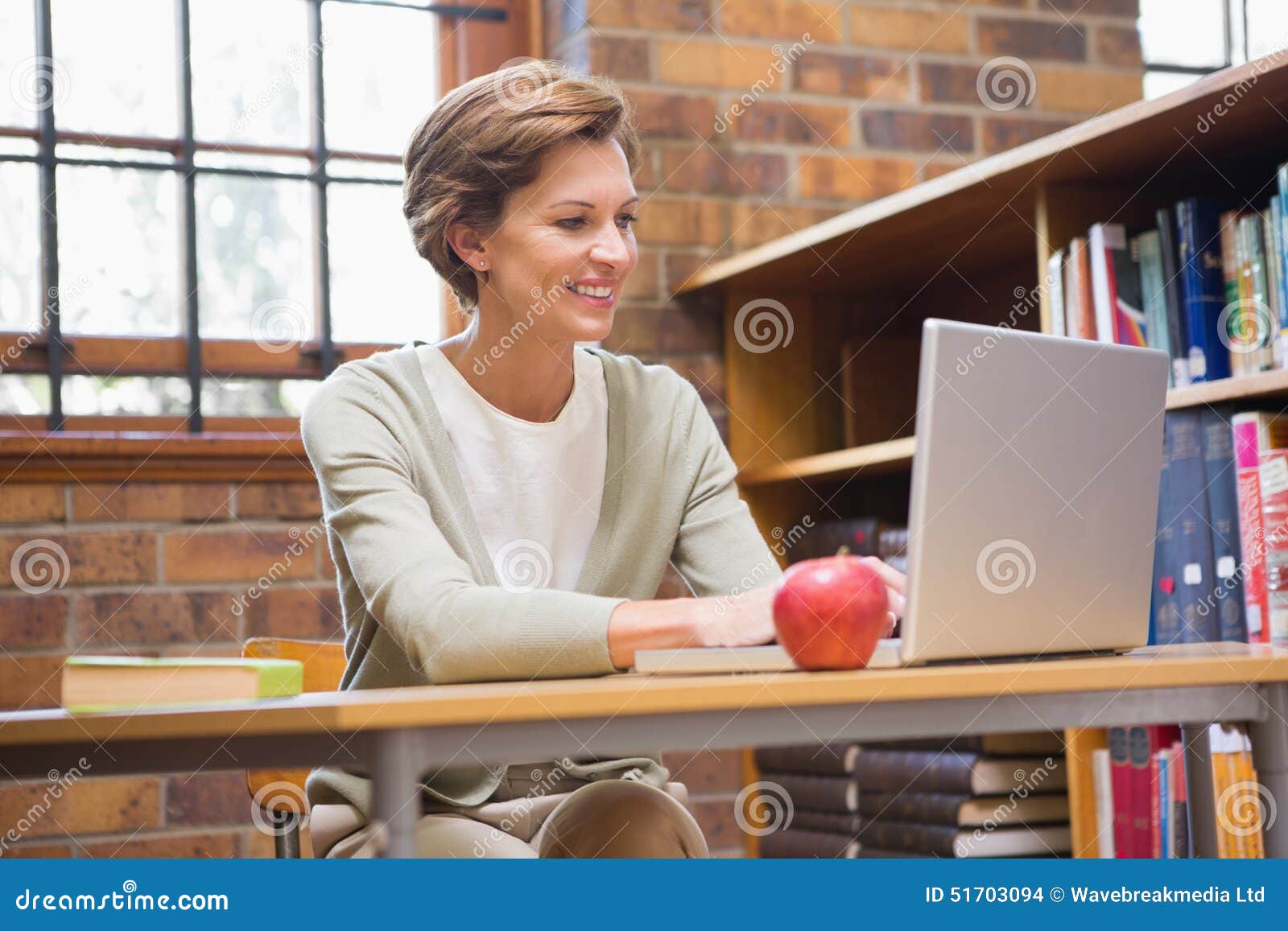 Smiling Teacher Using Laptop at a Desk Stock Photo - Image of notebook ...