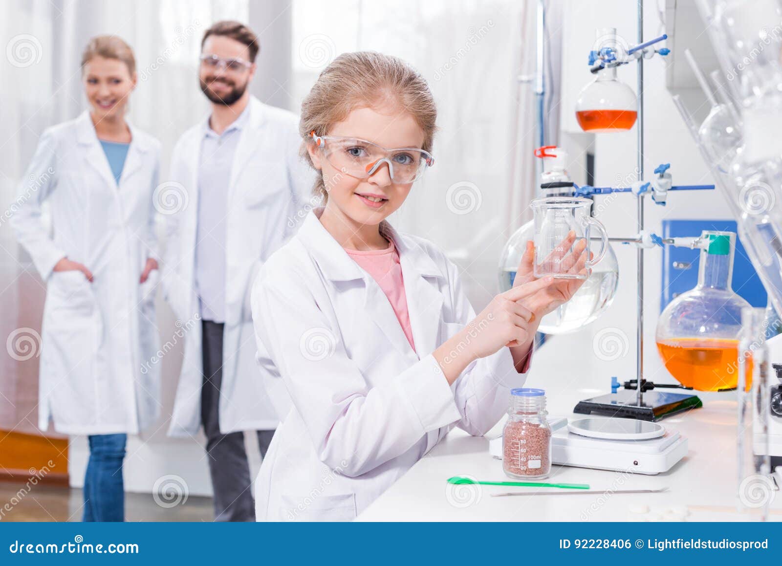 Smiling Teachers Looking at Little Student Making Experiment Stock ...
