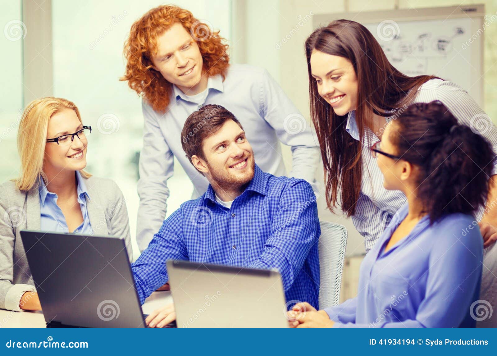 Smiling Team with Laptop Computers in Office Stock Photo - Image of ...