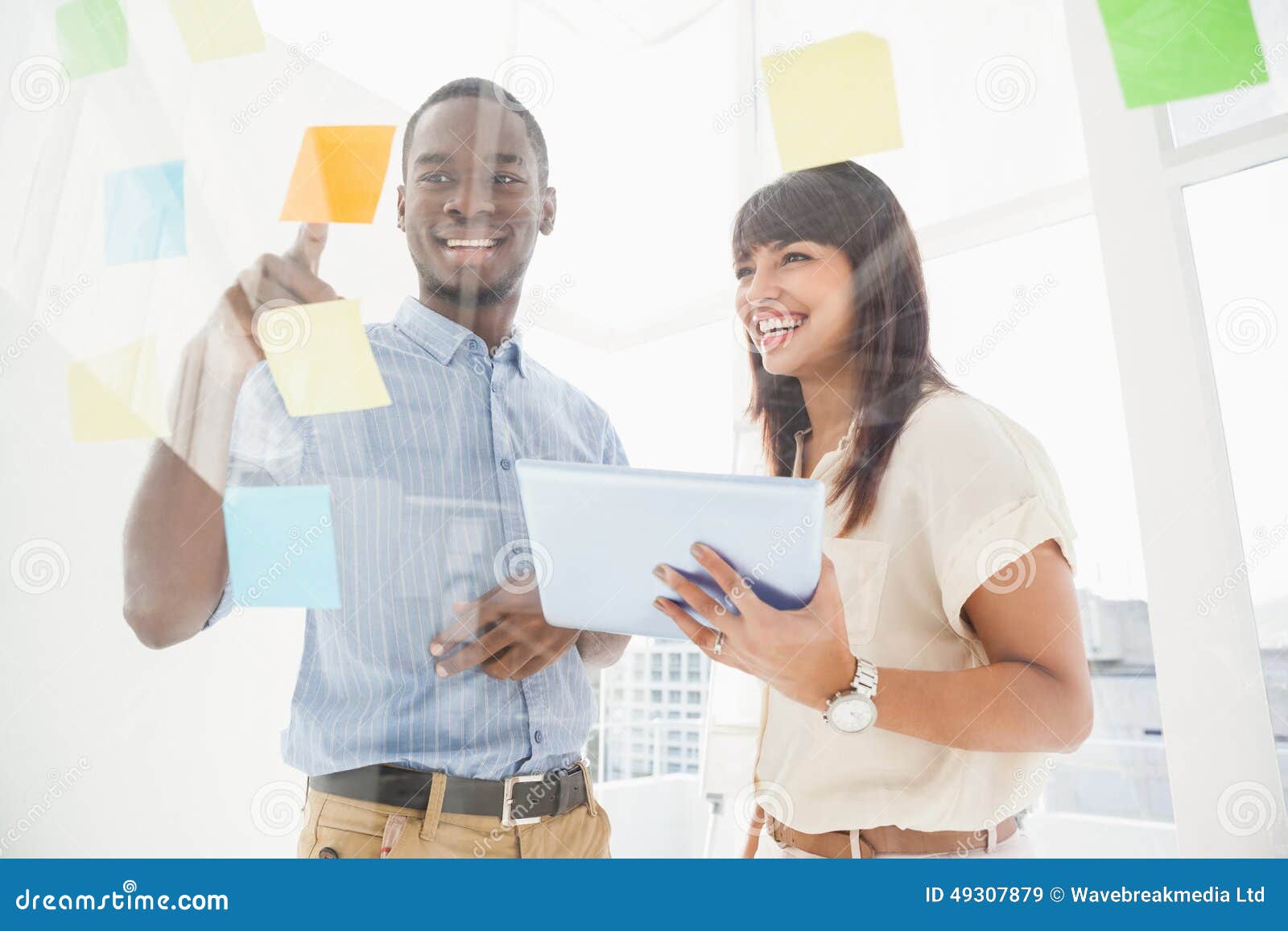 Smiling Teamwork Reading Sticky Notes and Using Tablet Stock Image ...