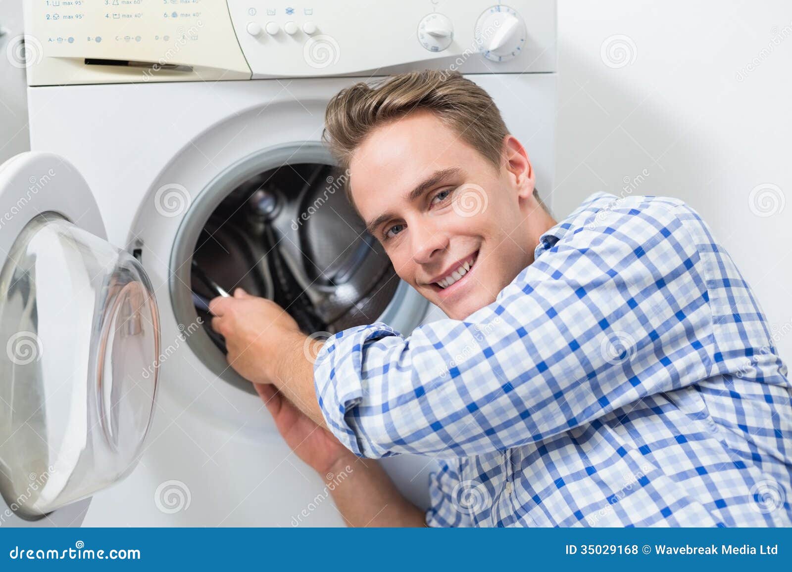 Smiling Technician Repairing a Washing Machine Stock Photo - Image of ...