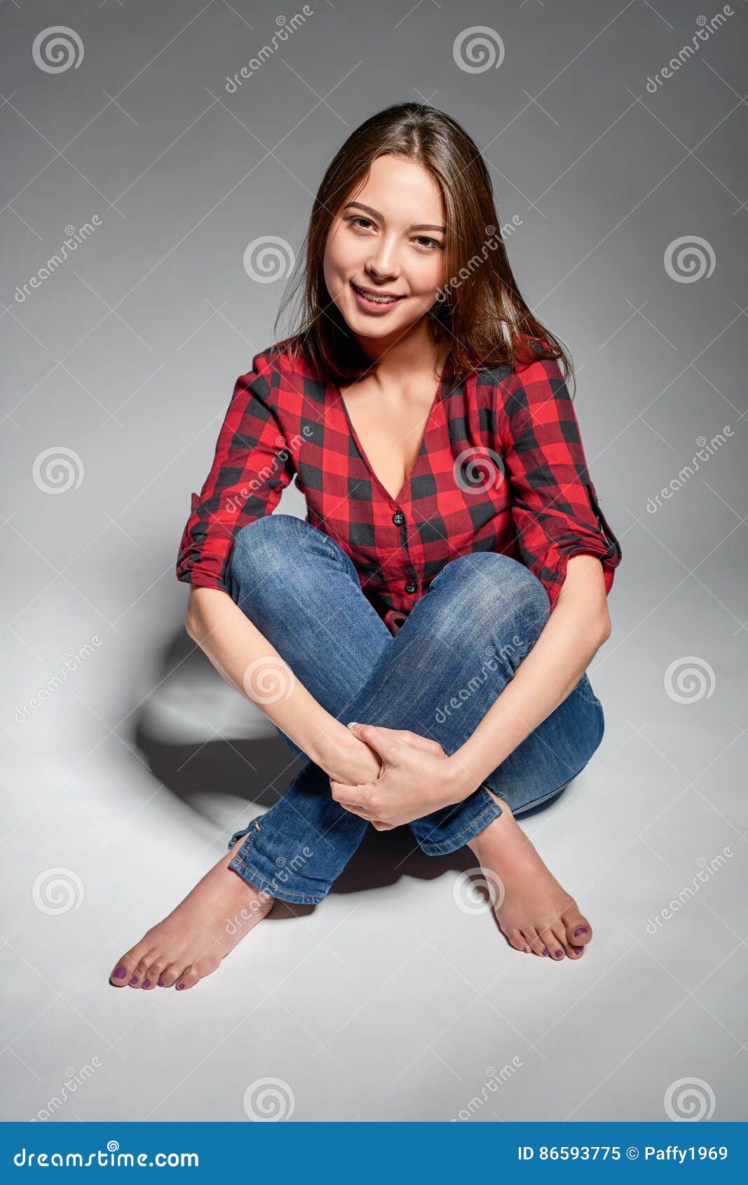 Smiling Teen Girl Sitting Barefooted At Floor Smiling At Camera Stock