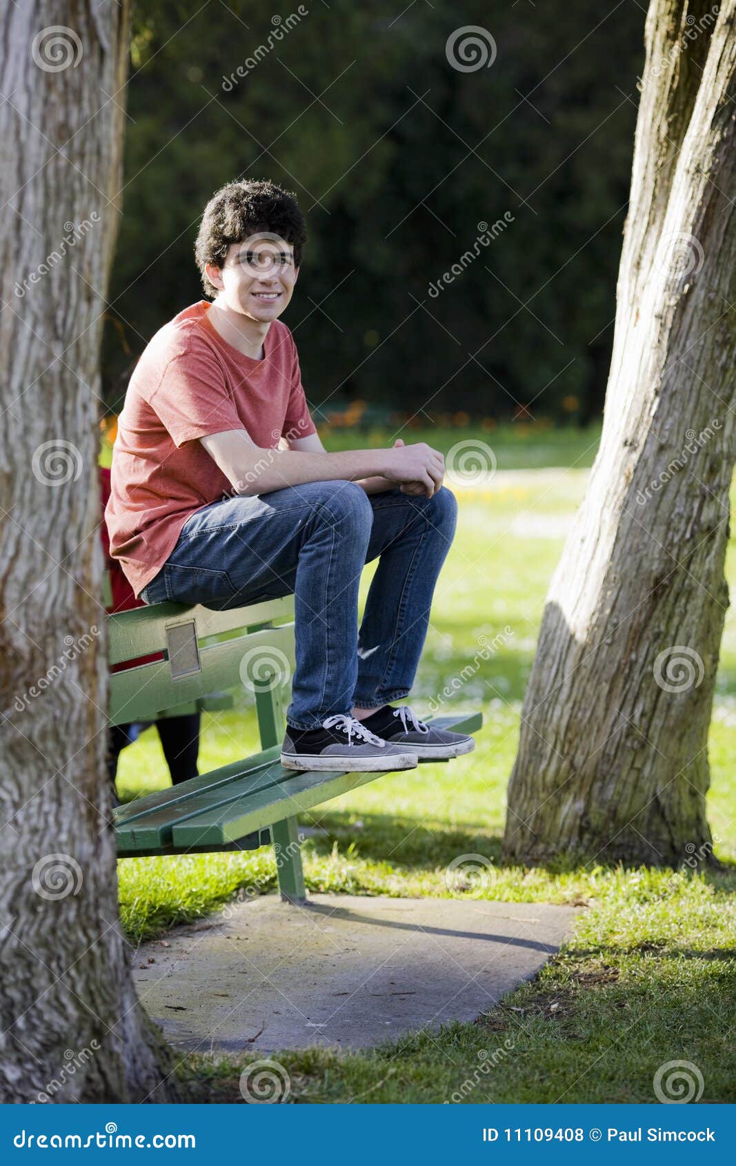 Smiling Teenage Boy Sitting on Bench Stock Photo - Image of park ...