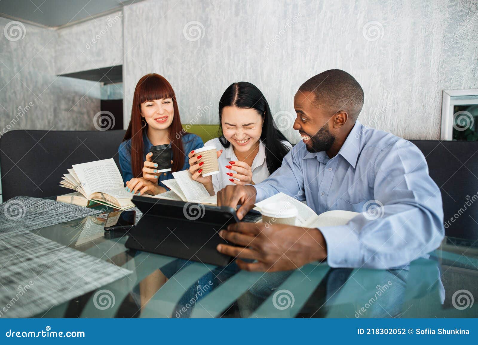 Smiling Three Multiracial Students or Colleagues, Sitting with Books in ...
