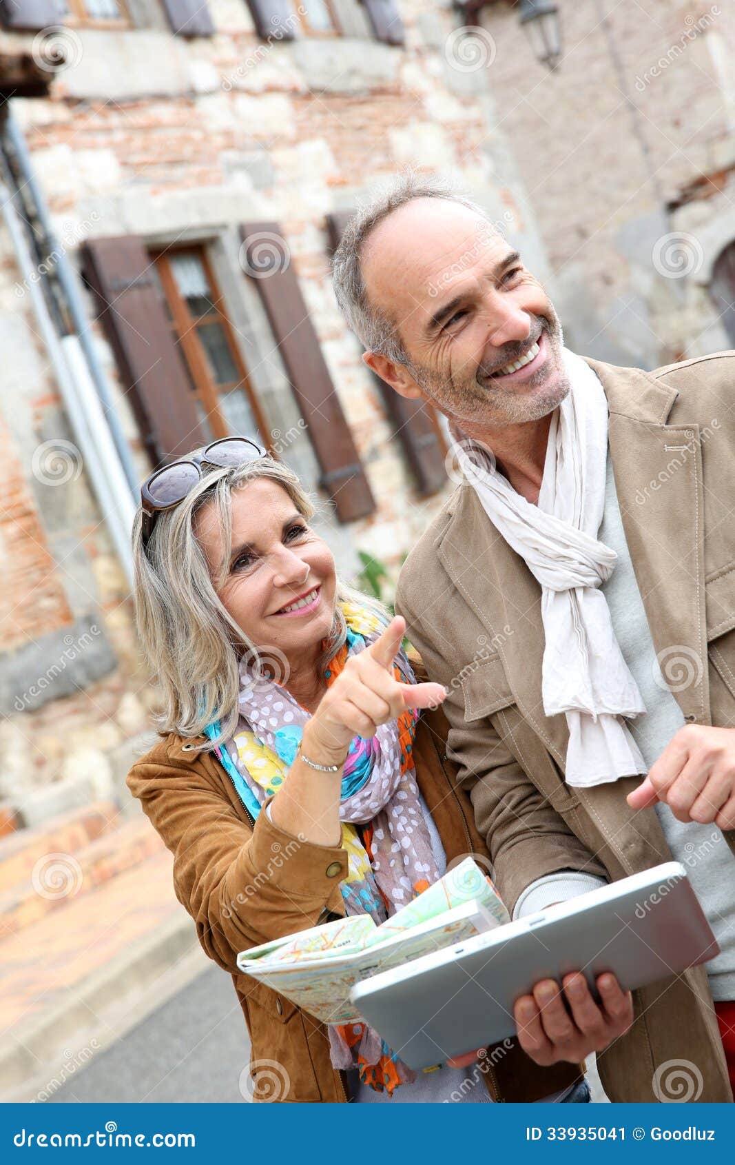 Smiling Tourists Using Tablet for a Good Visit of City Stock Image ...