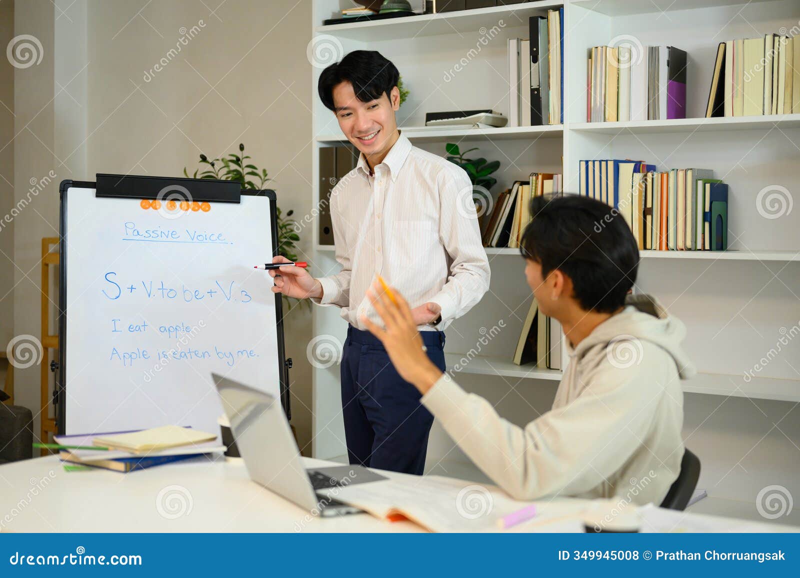 Smiling Tutor Standing by a Whiteboard To Explaining Grammar Rules for ...