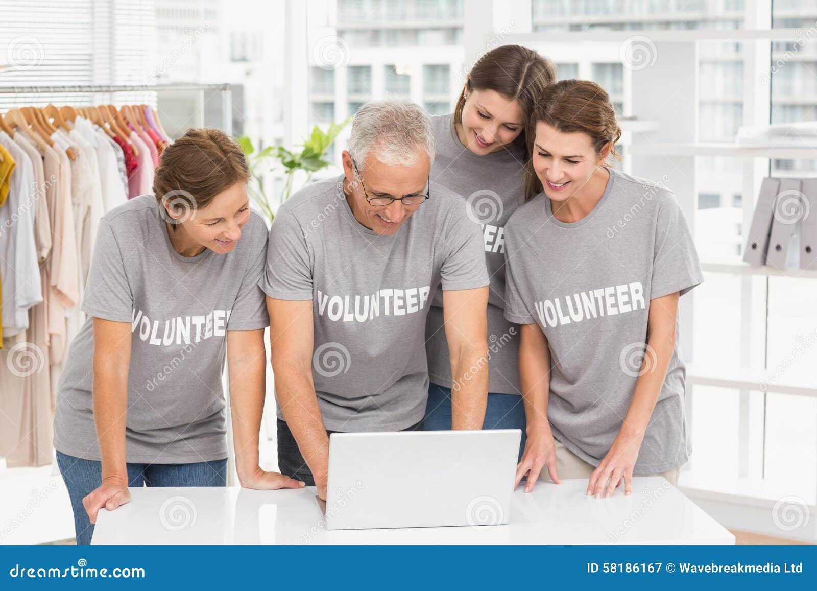 Smiling Volunteers Using Laptop Together Stock Image - Image of help ...
