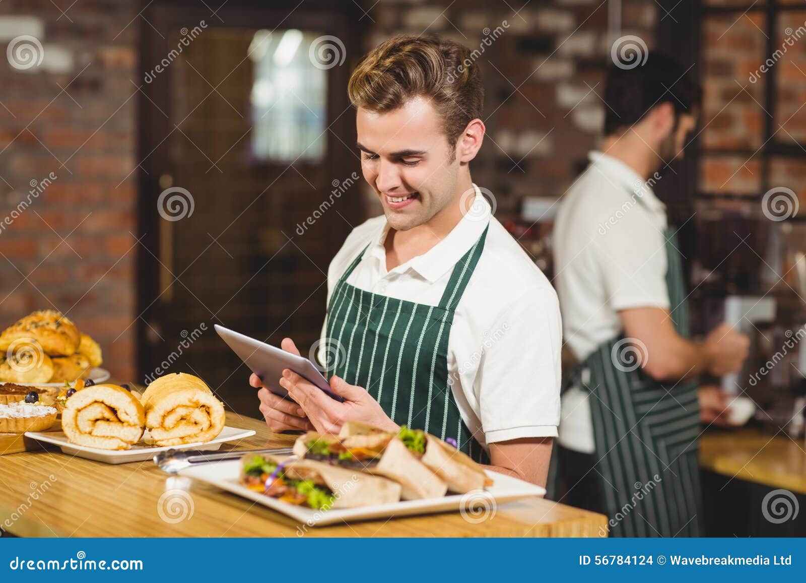 Smiling Waiter Using a Digital Tablet Stock Photo - Image of indoors ...