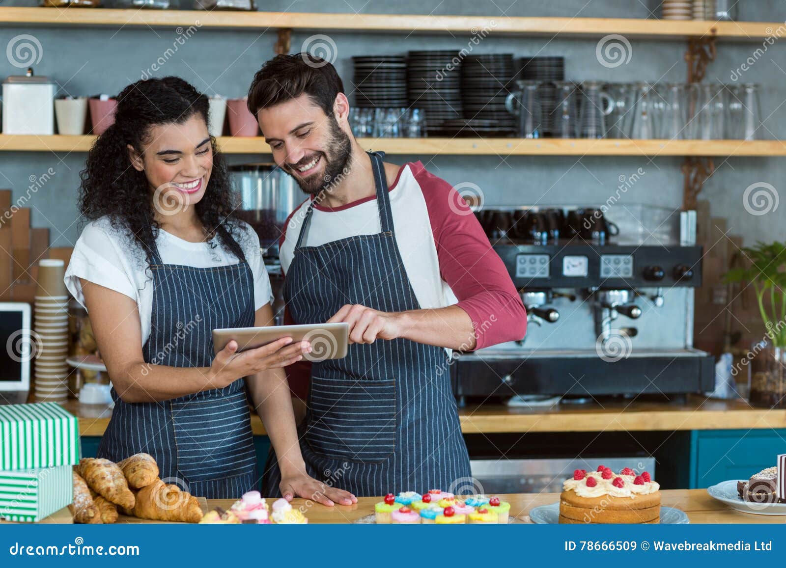 Smiling Waiter and Waitress Using Digital Tablet at Counter Stock Image ...