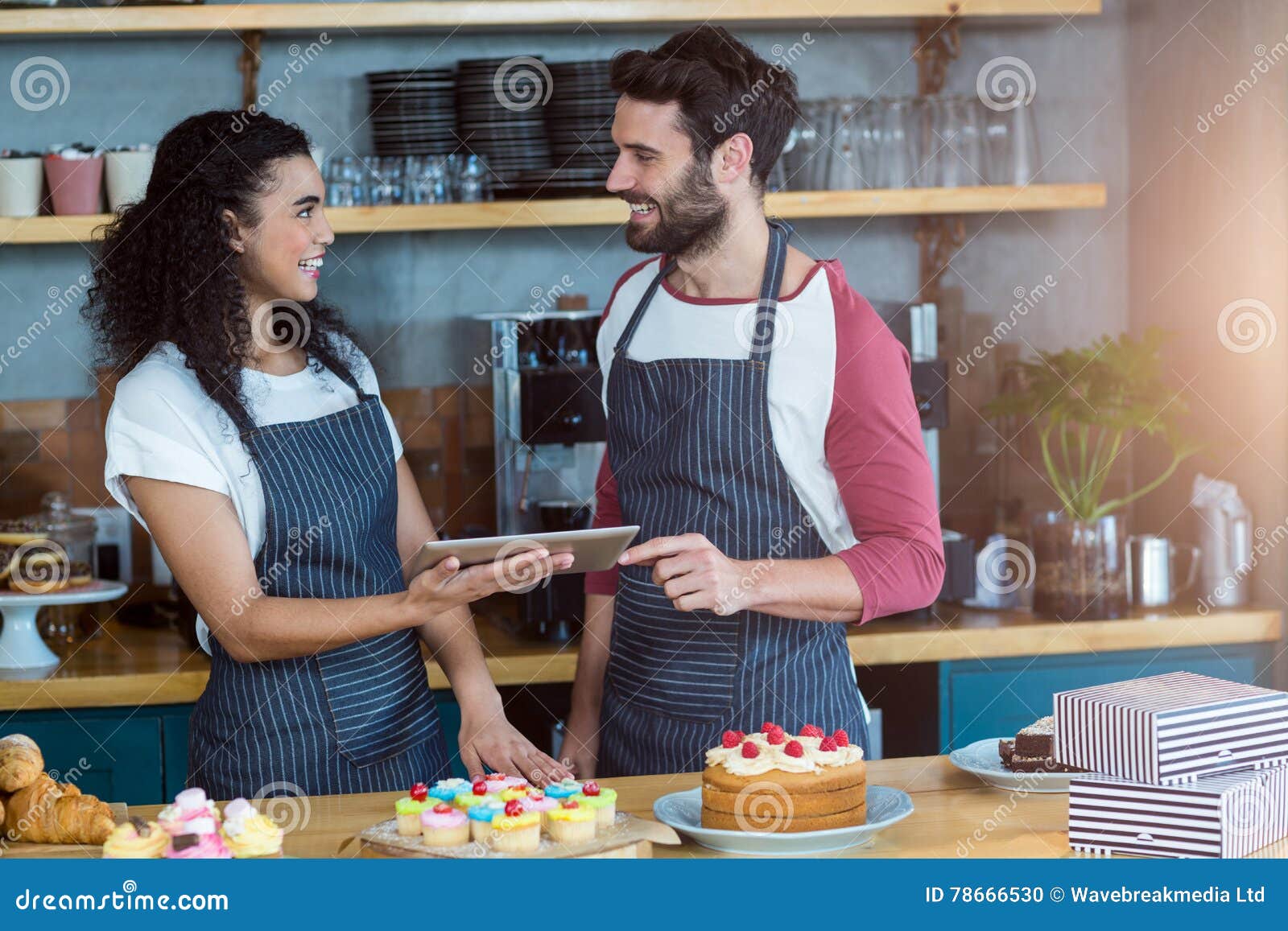 Smiling Waiter and Waitress Using Digital Tablet at Counter Stock Photo ...