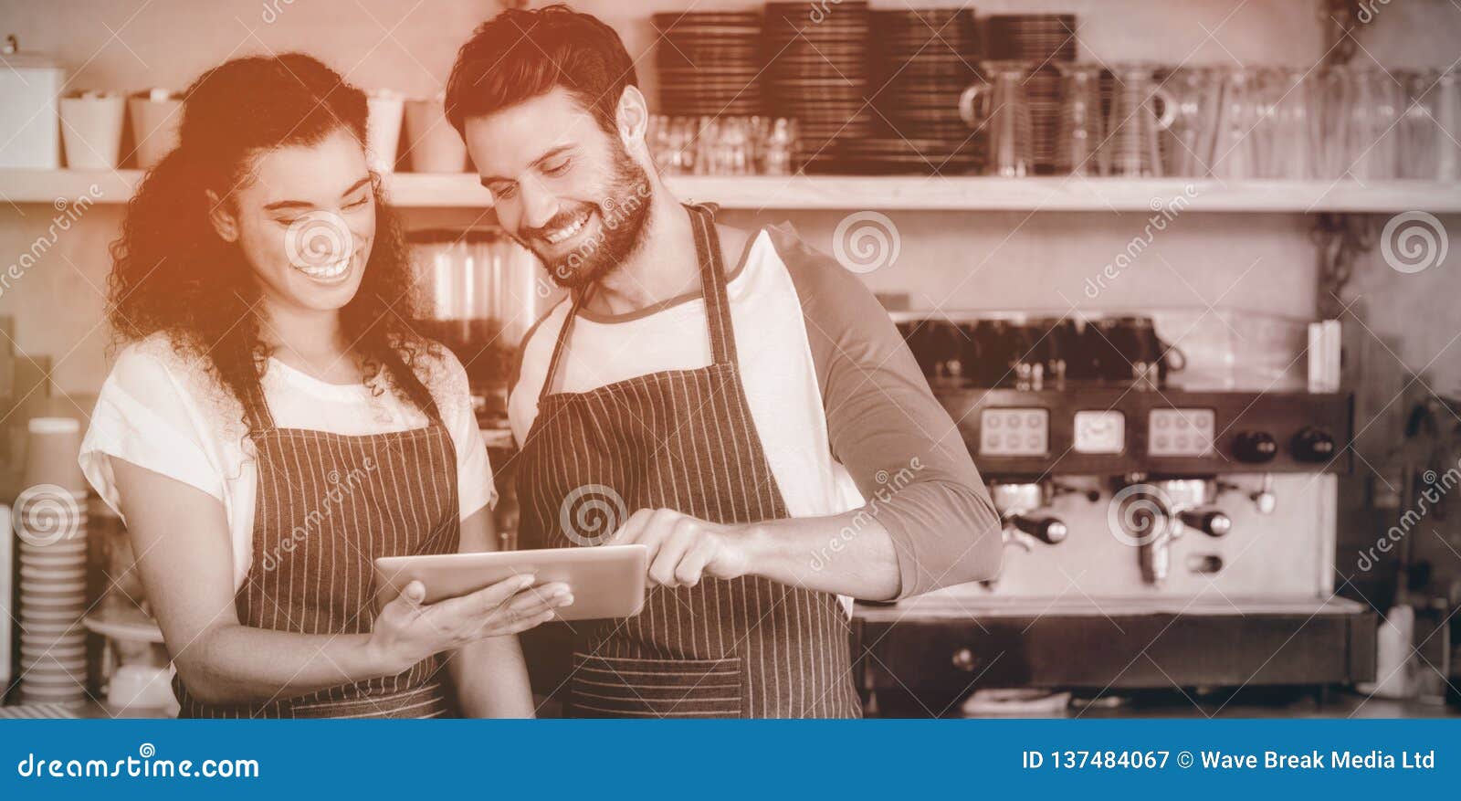 Smiling Waiter and Waitress Using Digital Tablet at Counter Stock Image ...