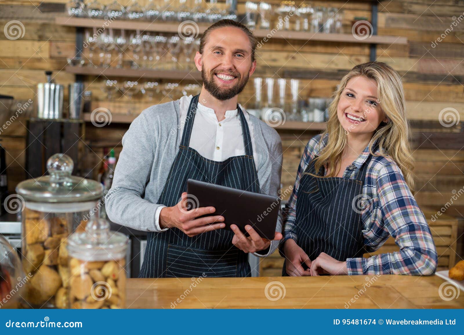 Smiling Waiter and Waitress Using Digital Tablet at Counter in Cafe ...