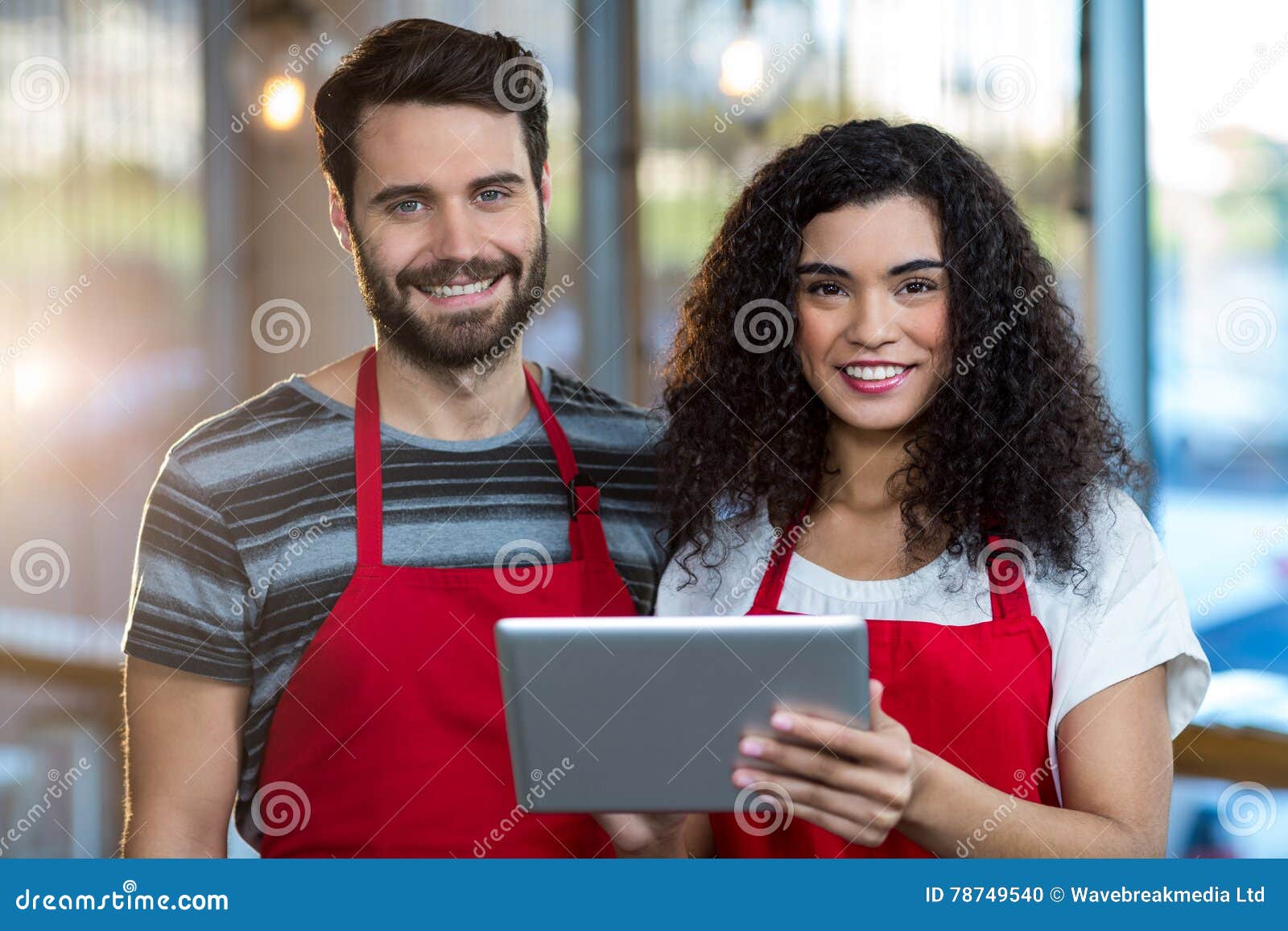 Smiling Waiter and Waitress Using Digital Tablet at Counter Stock Photo ...