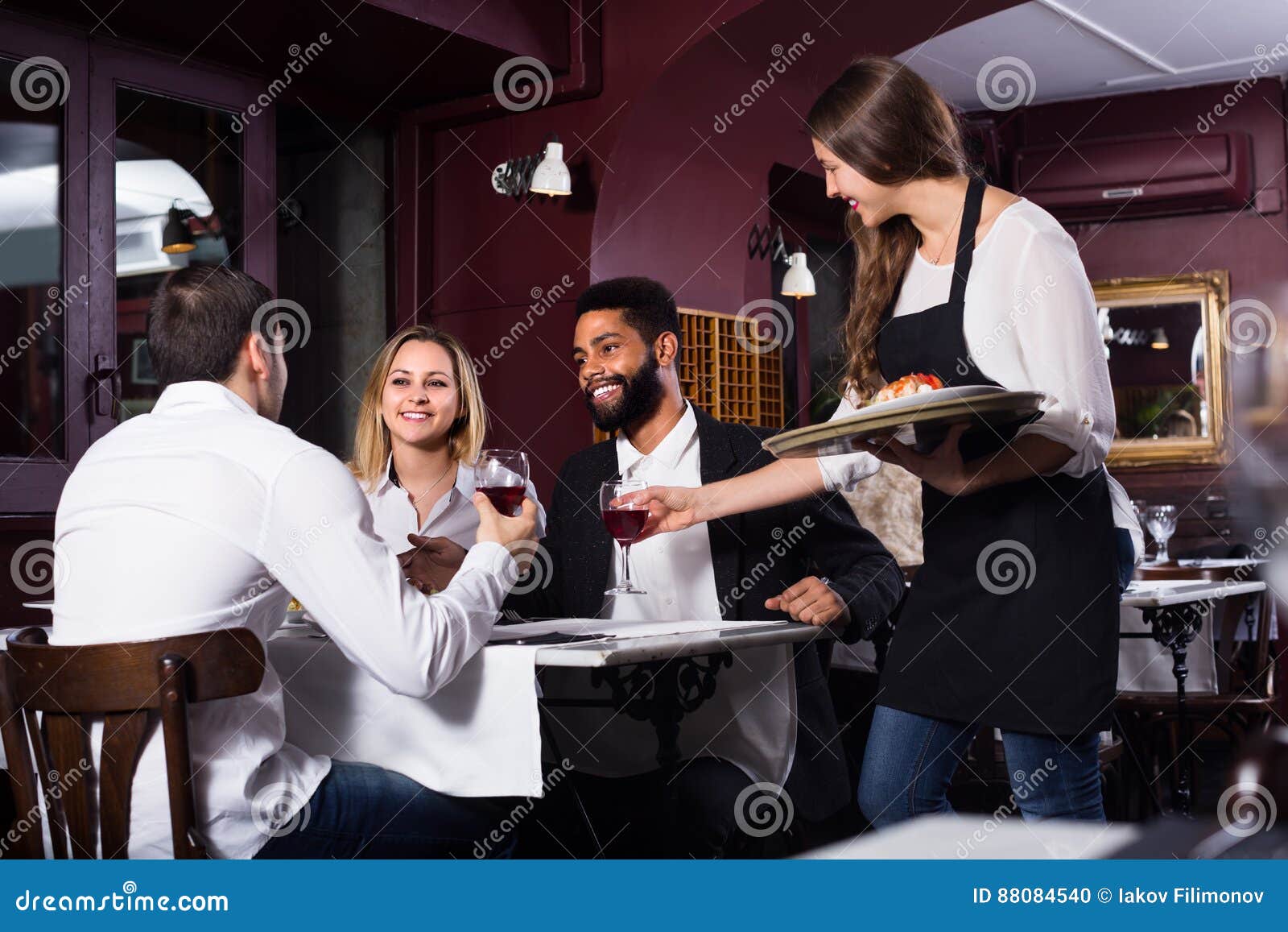 Smiling Waitress and Guests at the Table Stock Photo - Image of hanging ...