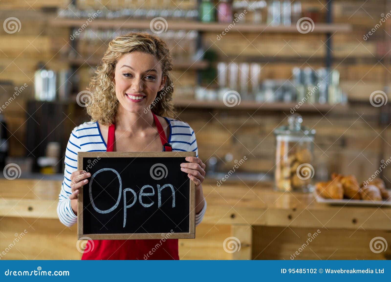 Smiling Waitress Standing with Open Signboard in Cafe Stock Photo ...