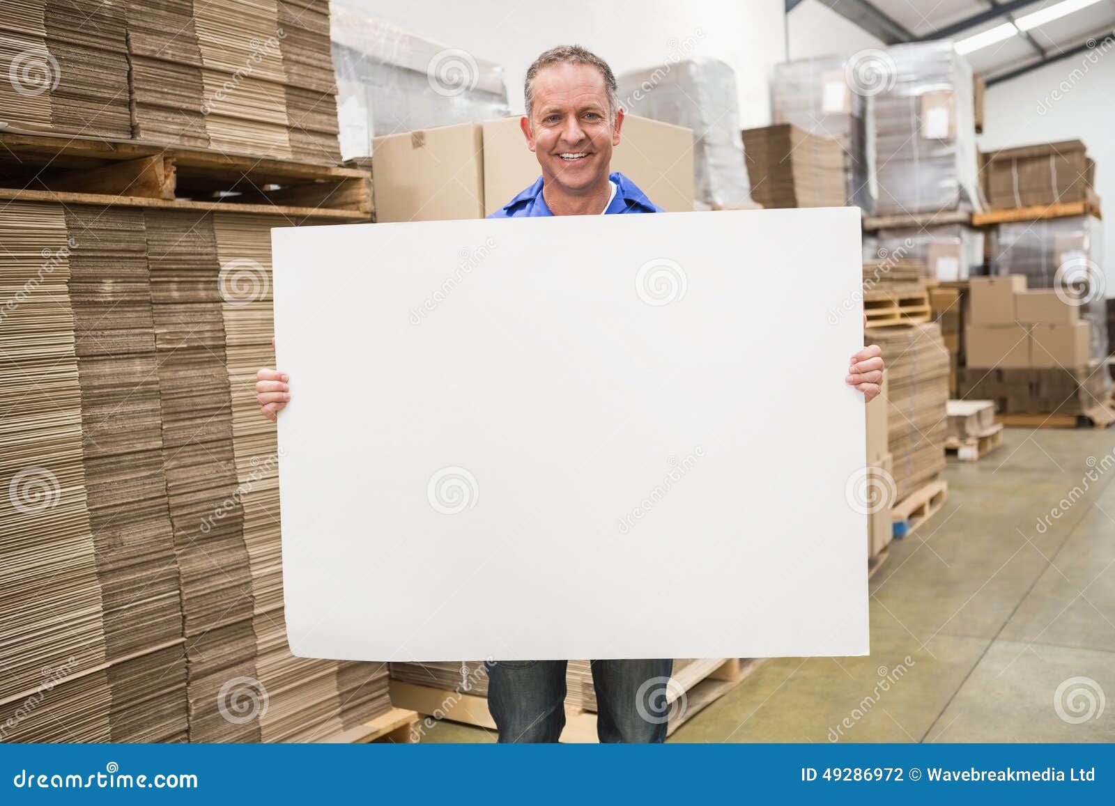 Smiling Warehouse Worker Holding Large White Poster Stock Photo - Image ...