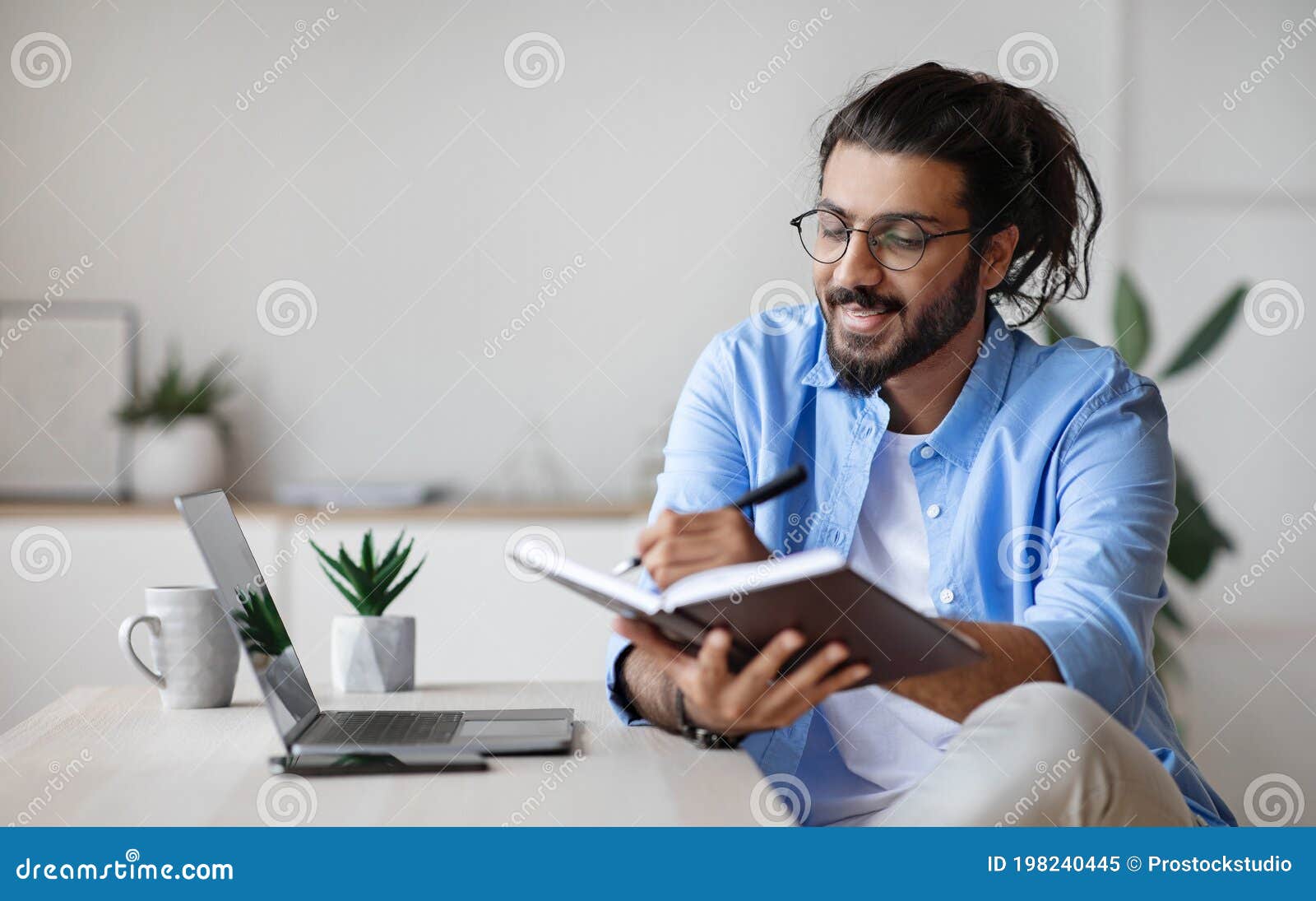 Smiling Western Freelancer Guy Taking Notes at Workplace in Home Office ...