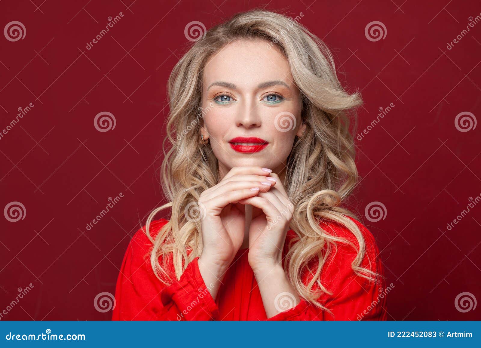 Smiling Woman With Blonde Hair And Natural Manicured Nails On Vivid Red