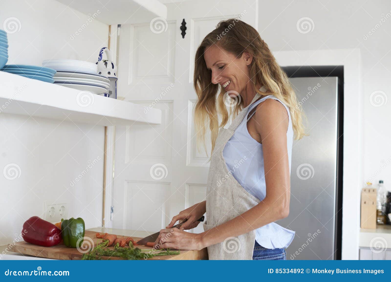 Smiling Woman Chopping Vegetables in Kitchen Stock Photo - Image of ...