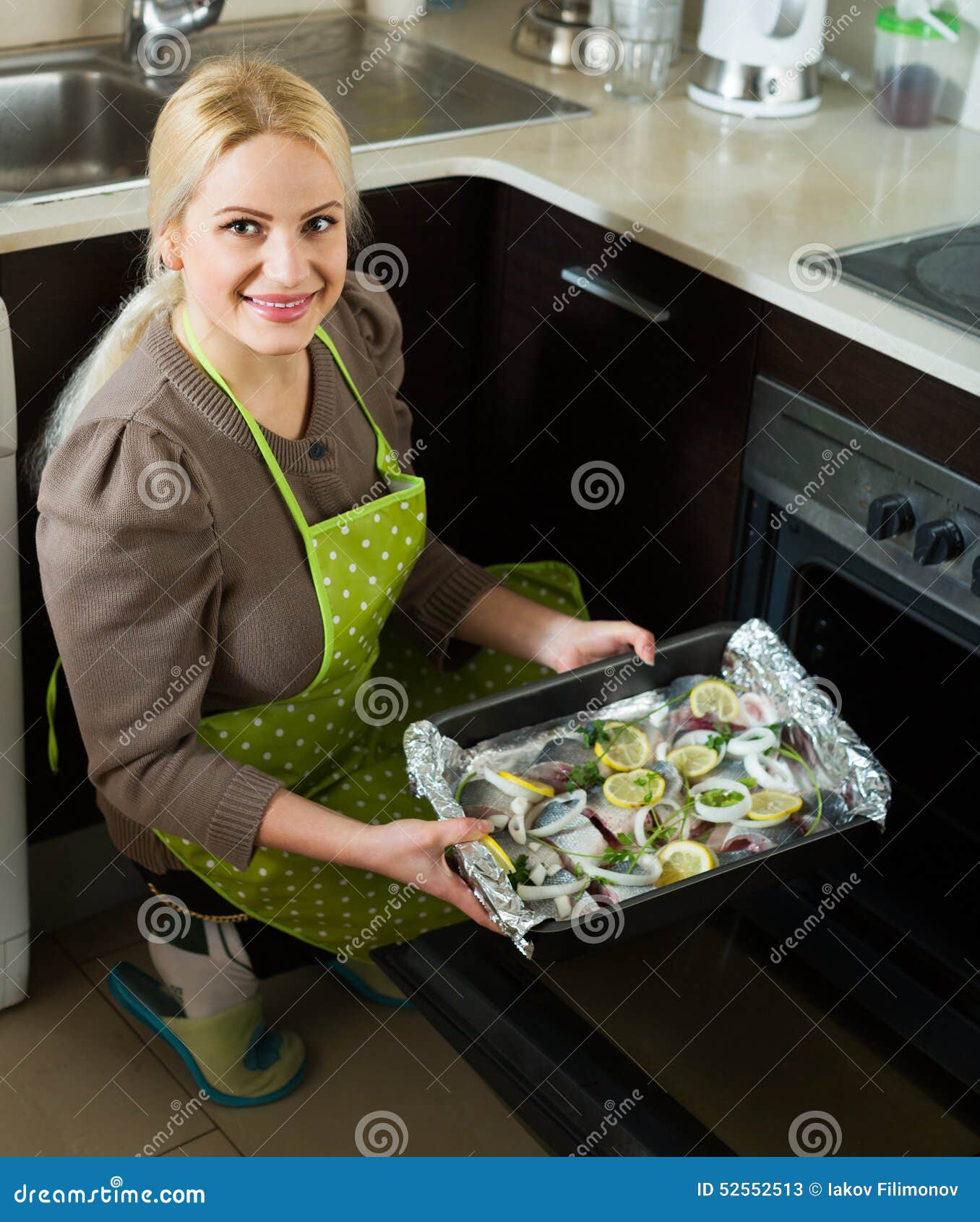 Smiling woman cooking fish stock image. Image of bake - 52552513