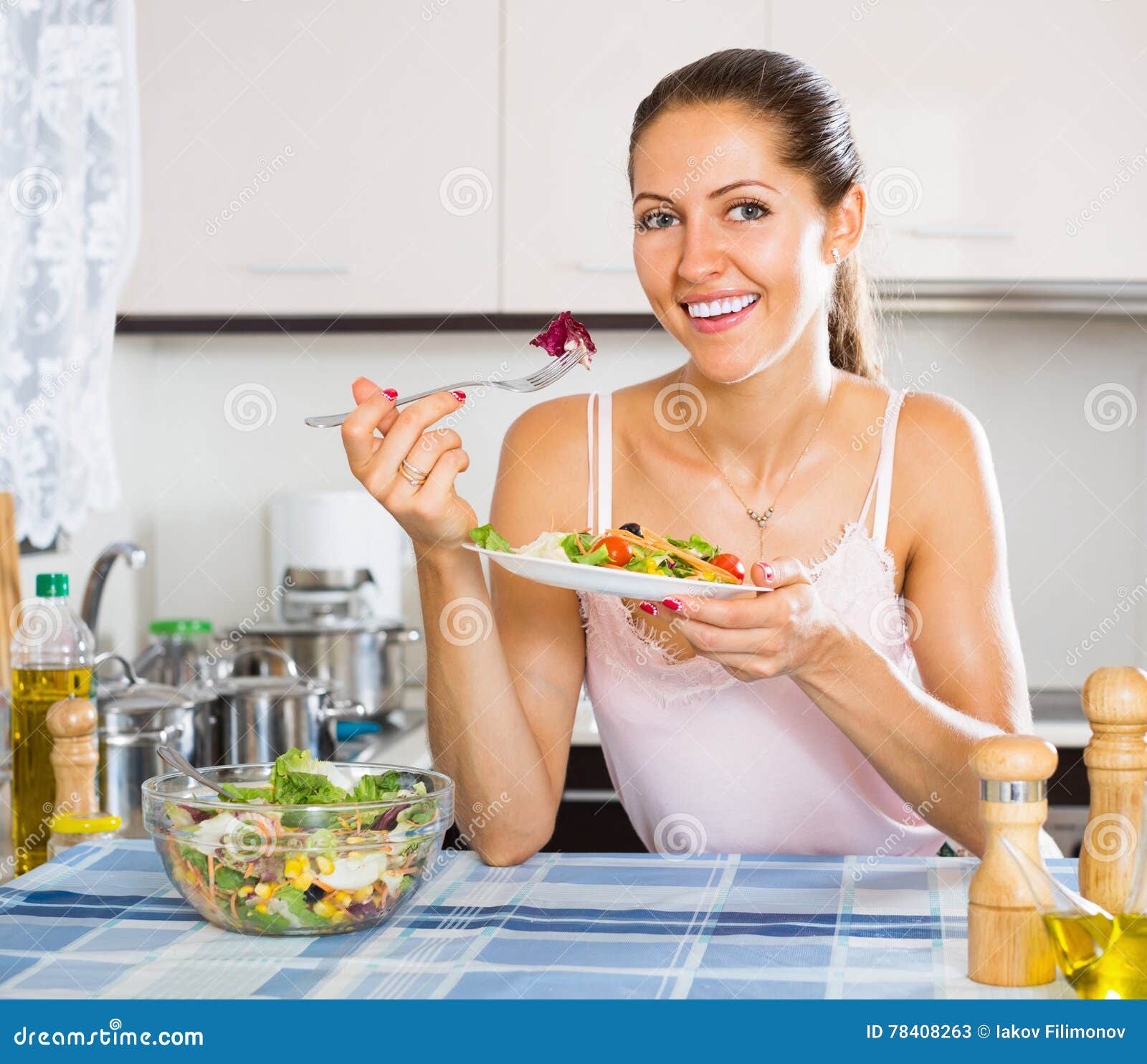 Smiling Woman Eating at Kitchen Table Stock Image - Image of olive ...